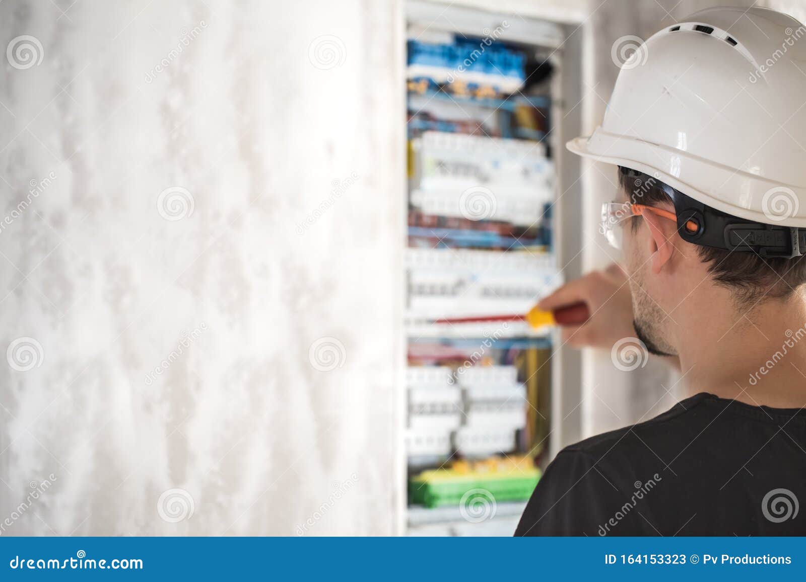 Man, an Electrical Technician Working in a Switchboard with Fuses ...