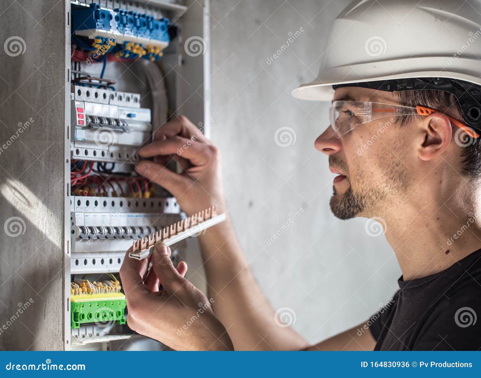 Man, an Electrical Technician Working in a Switchboard with Fuses ...
