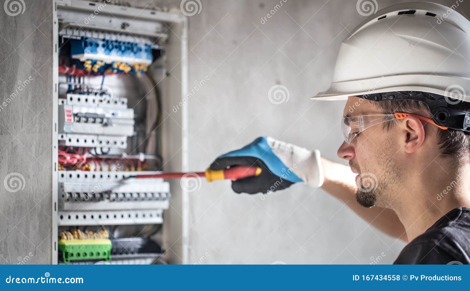 Man, an Electrical Technician Working in a Switchboard with Fuses ...