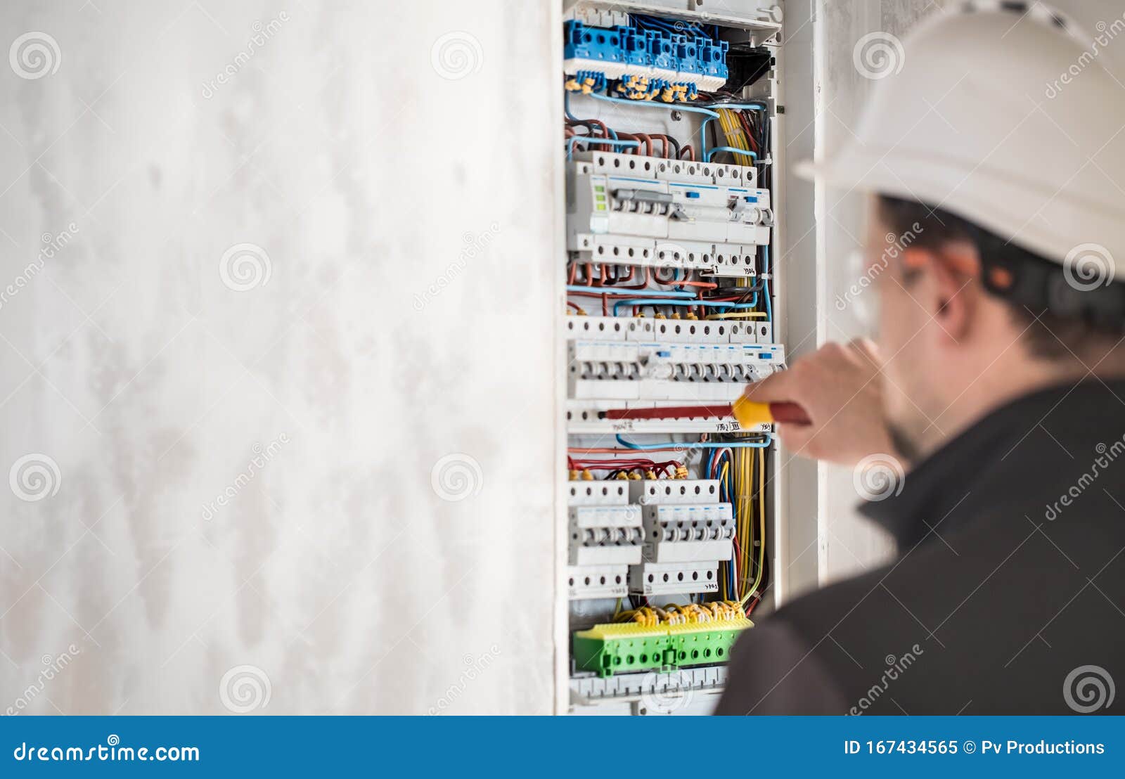Man, an Electrical Technician Working in a Switchboard with Fuses ...