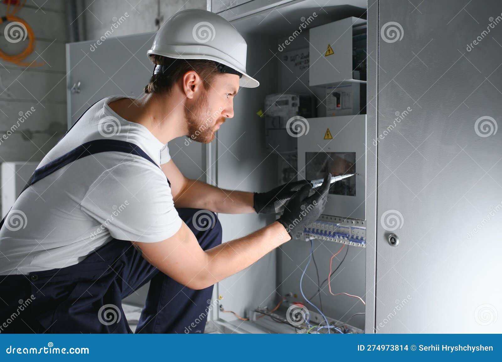 Man, an Electrical Technician Working in a Switchboard with Fuses ...