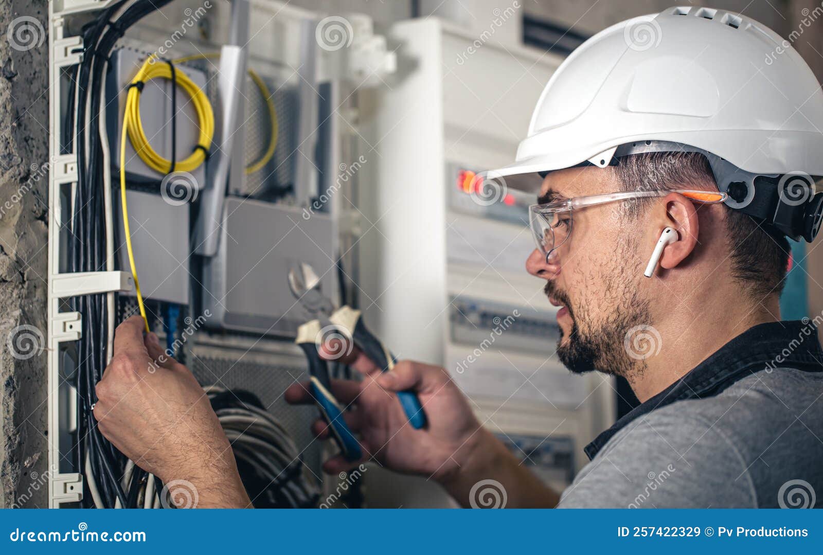 Man, an Electrical Technician Working in a Switchboard with Fuses ...