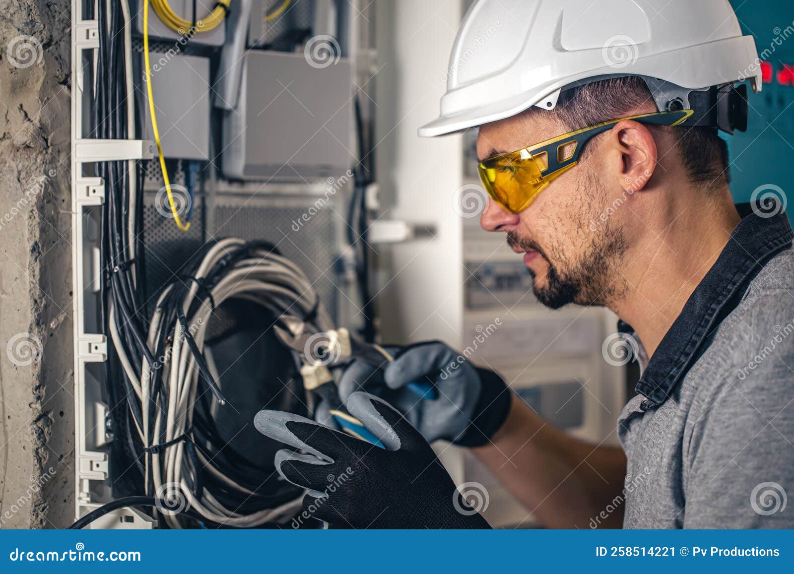 Man, an Electrical Technician Working in a Switchboard with Fuses ...