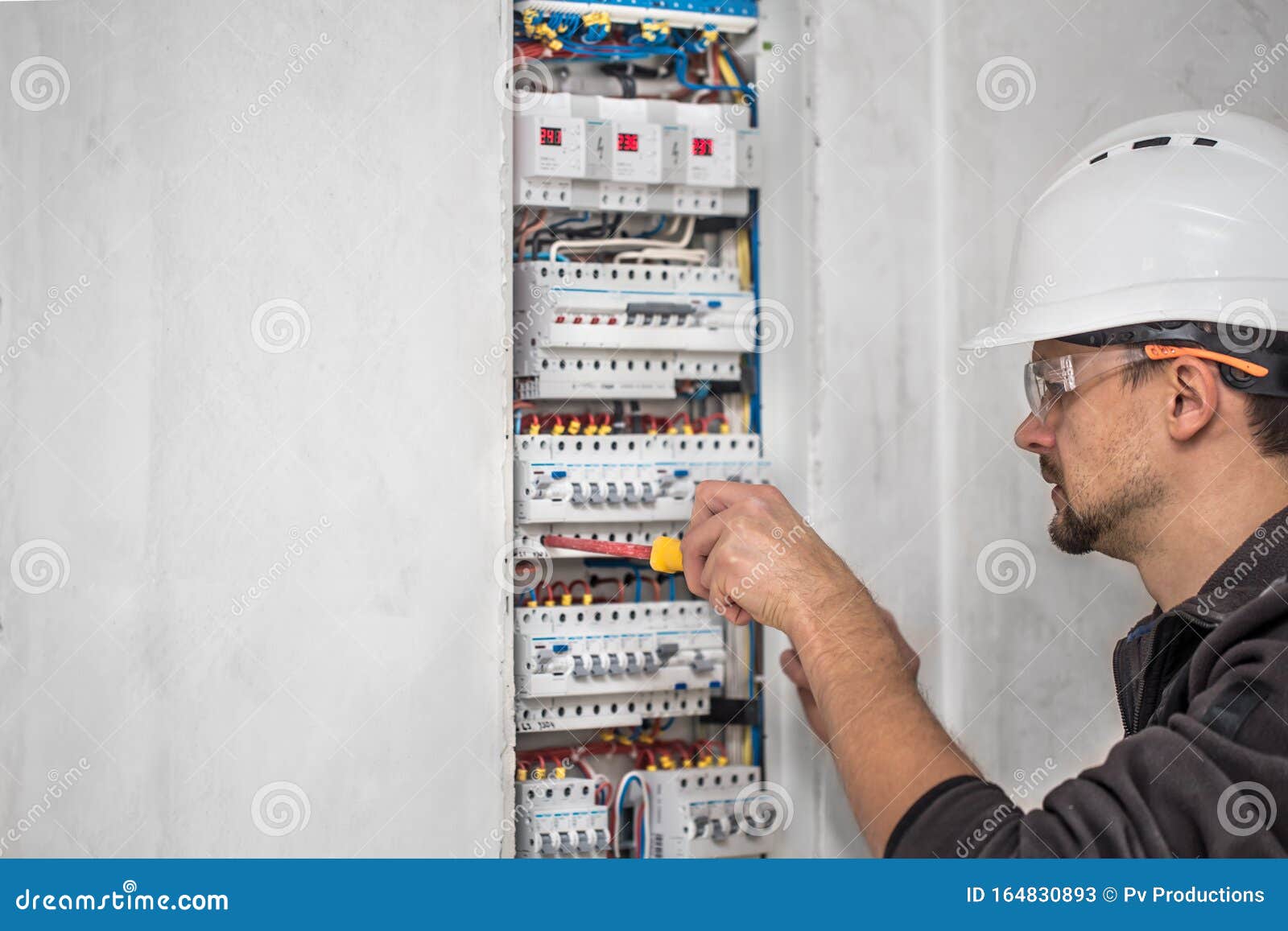 Man, an Electrical Technician Working in a Switchboard with Fuses ...
