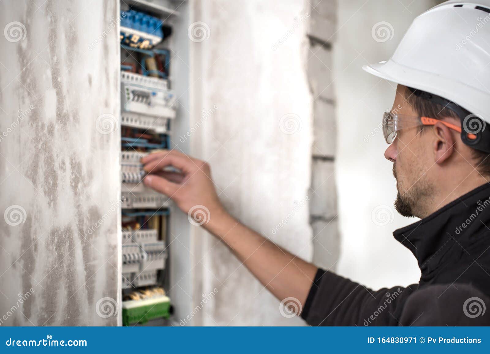 Man, an Electrical Technician Working in a Switchboard with Fuses ...