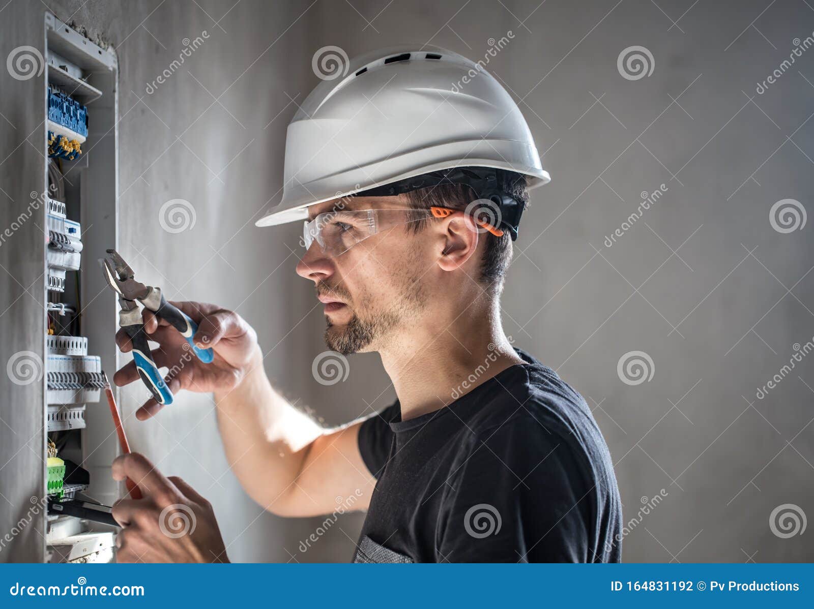 Man, an Electrical Technician Working in a Switchboard with Fuses ...