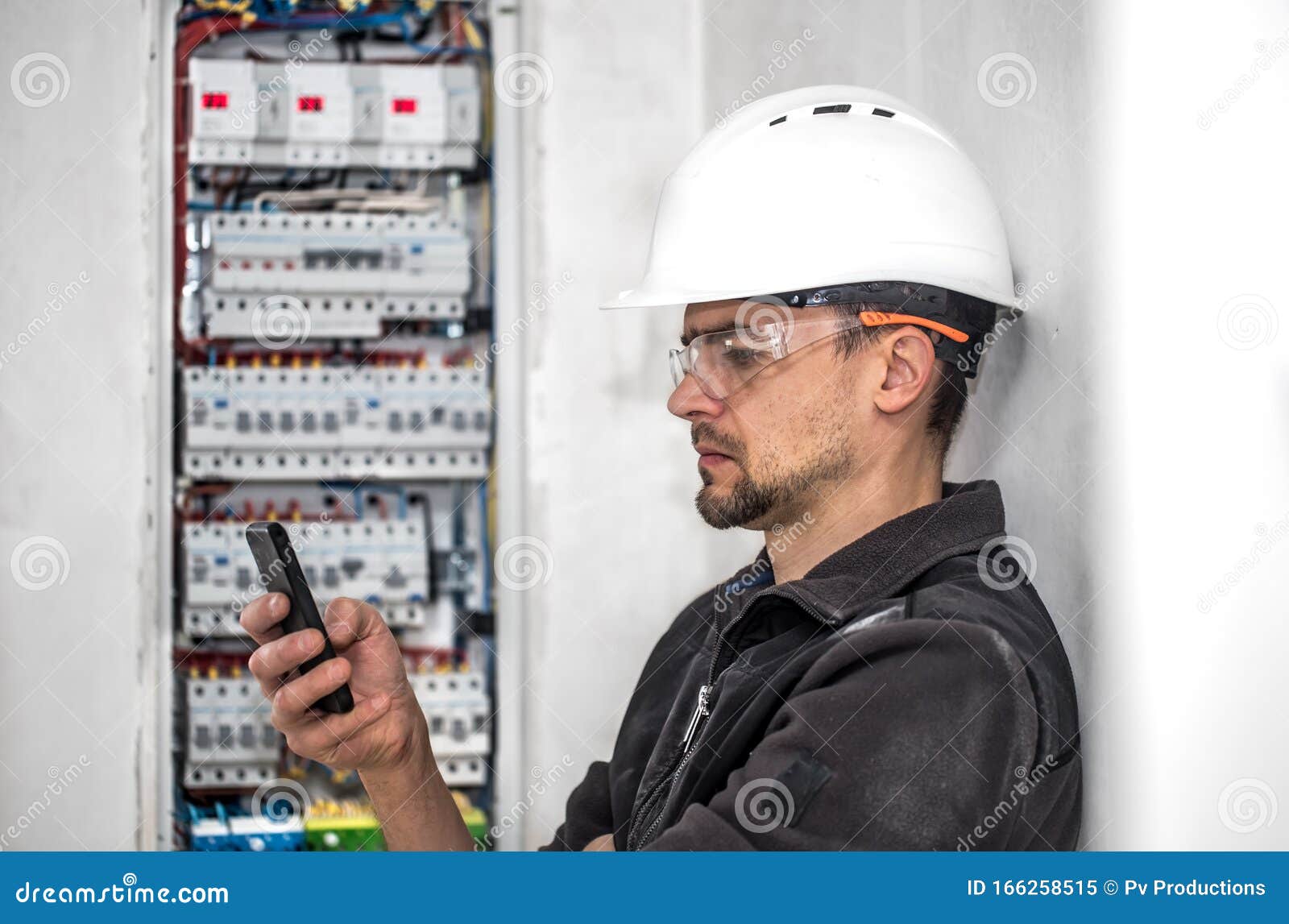 Man, an Electrical Technician Working in a Switchboard with Fuses ...