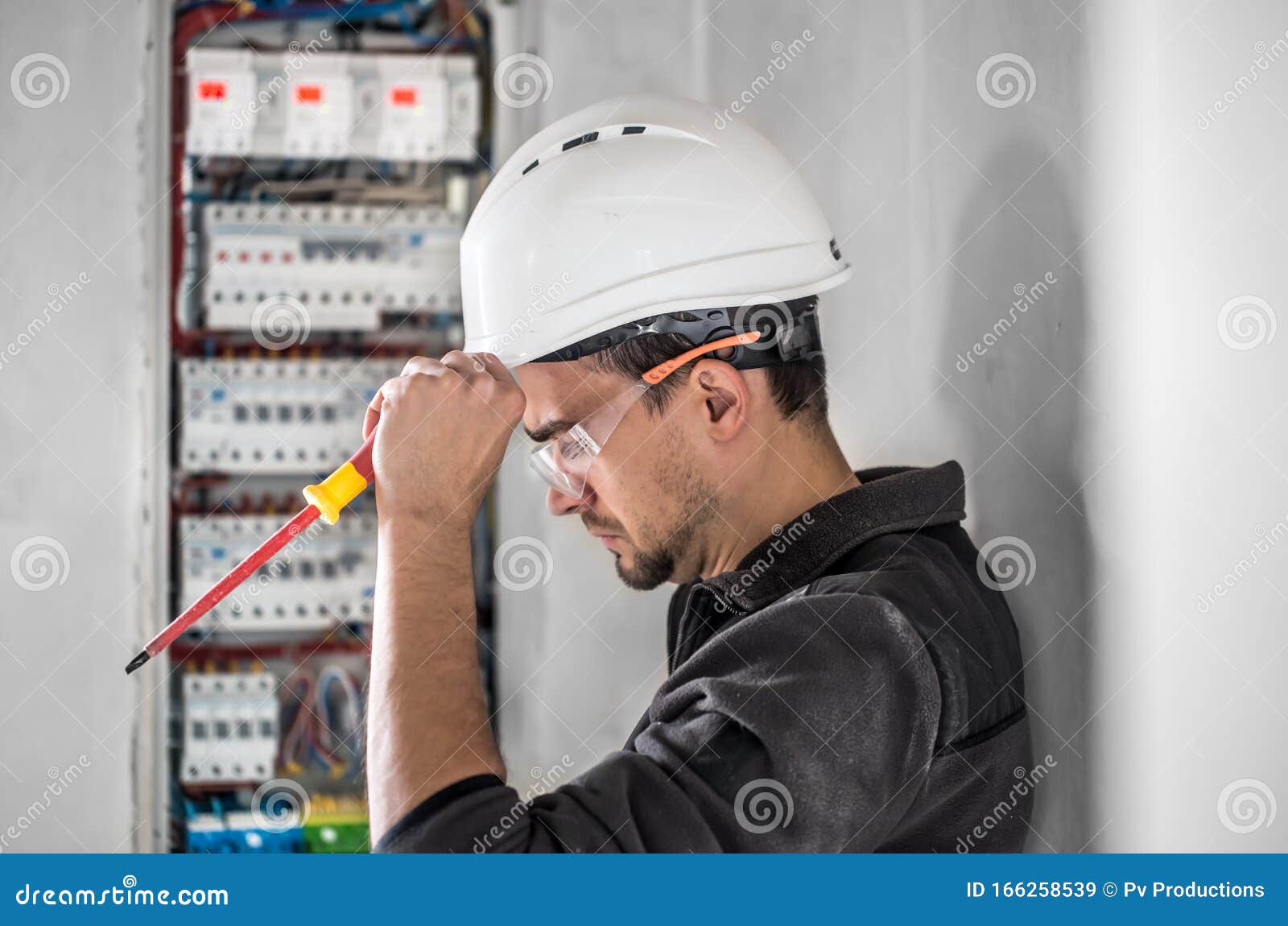 Man, an Electrical Technician Working in a Switchboard with Fuses ...