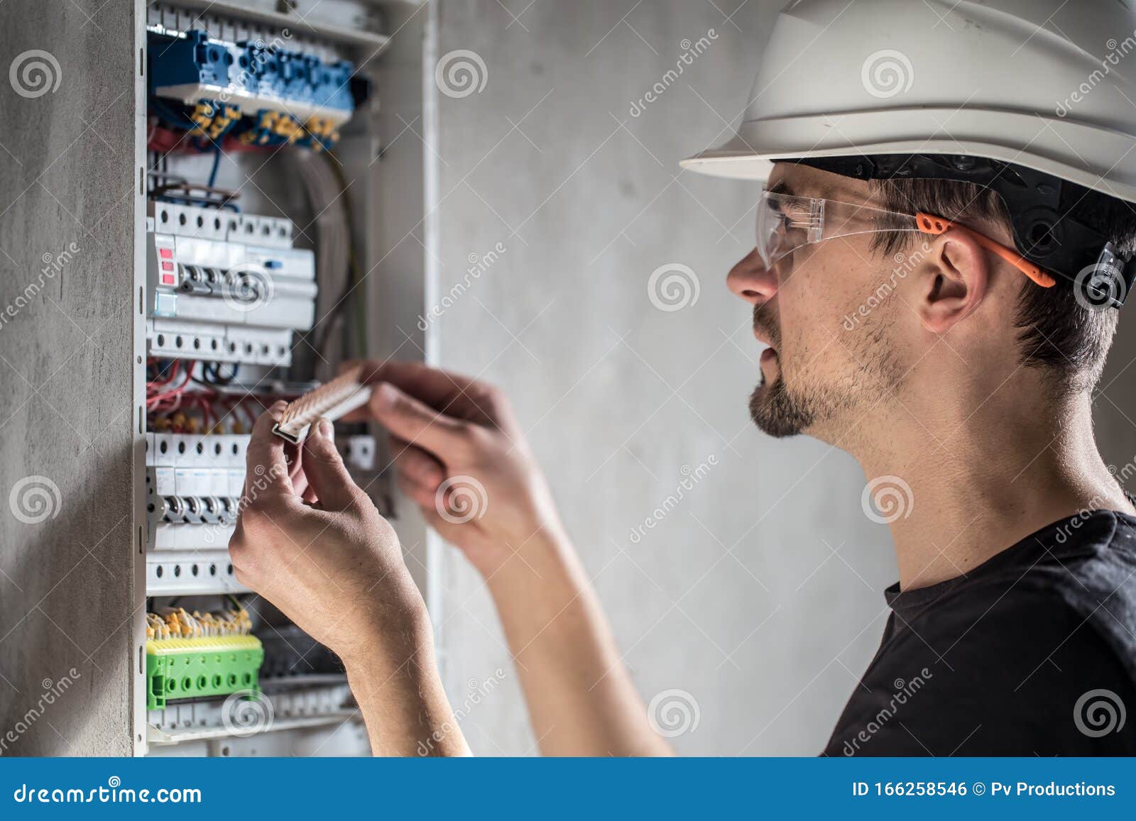 Man, an Electrical Technician Working in a Switchboard with Fuses ...