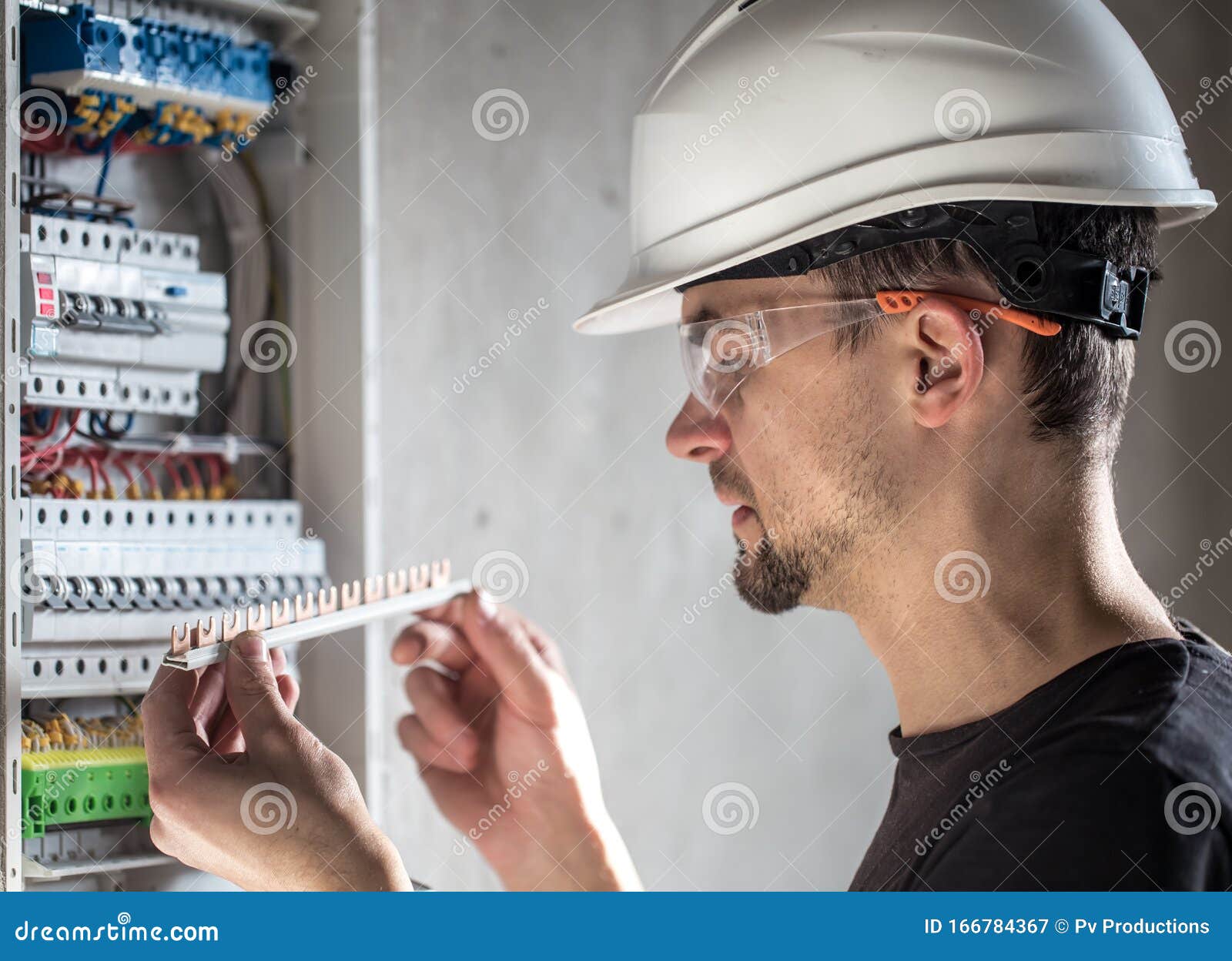Man, an Electrical Technician Working in a Switchboard with Fuses ...