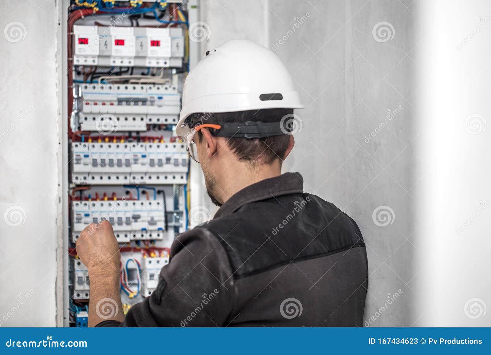 Man, an Electrical Technician Working in a Switchboard with Fuses ...