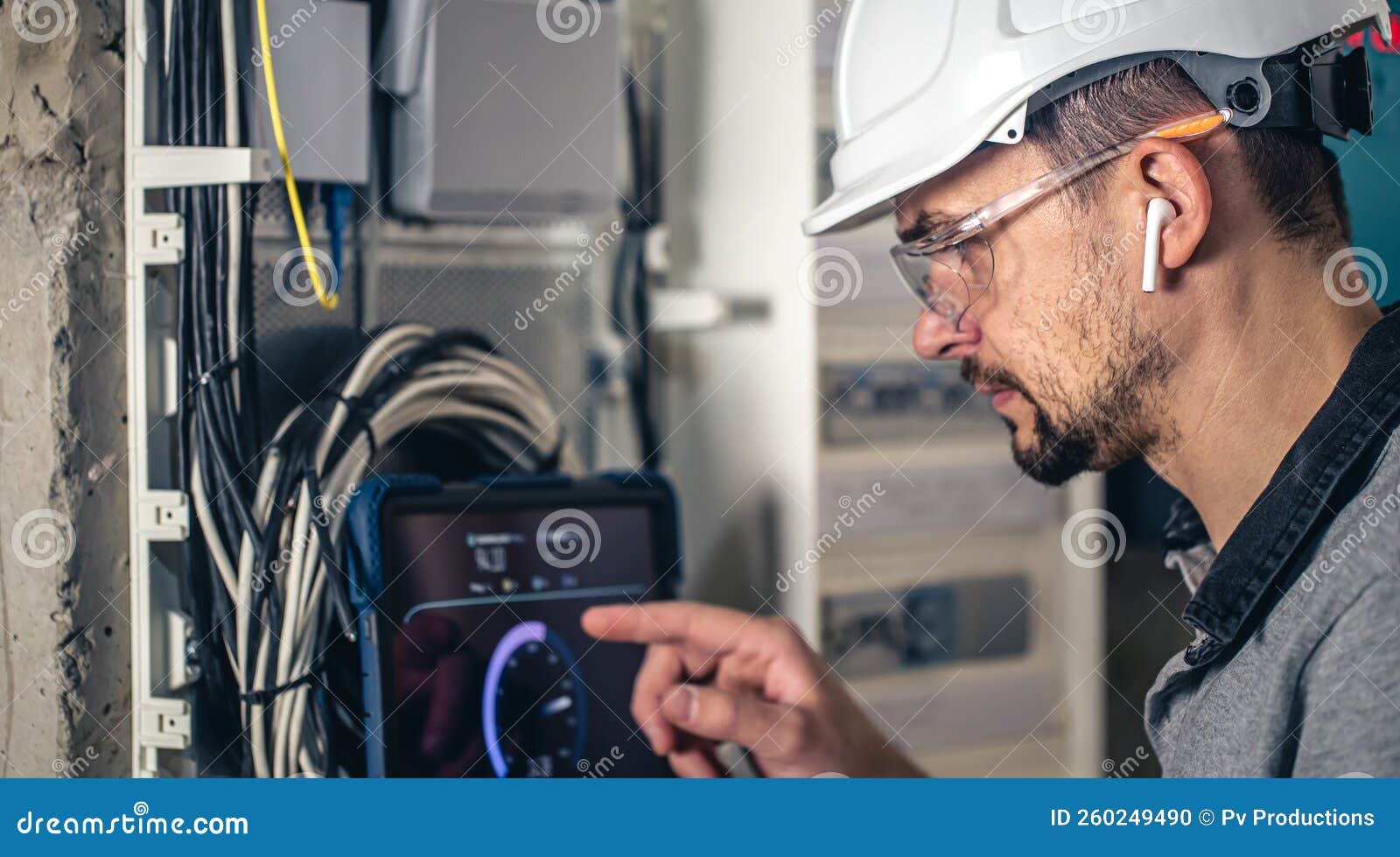 Man, an Electrical Technician Working in a Switchboard with Fuses ...