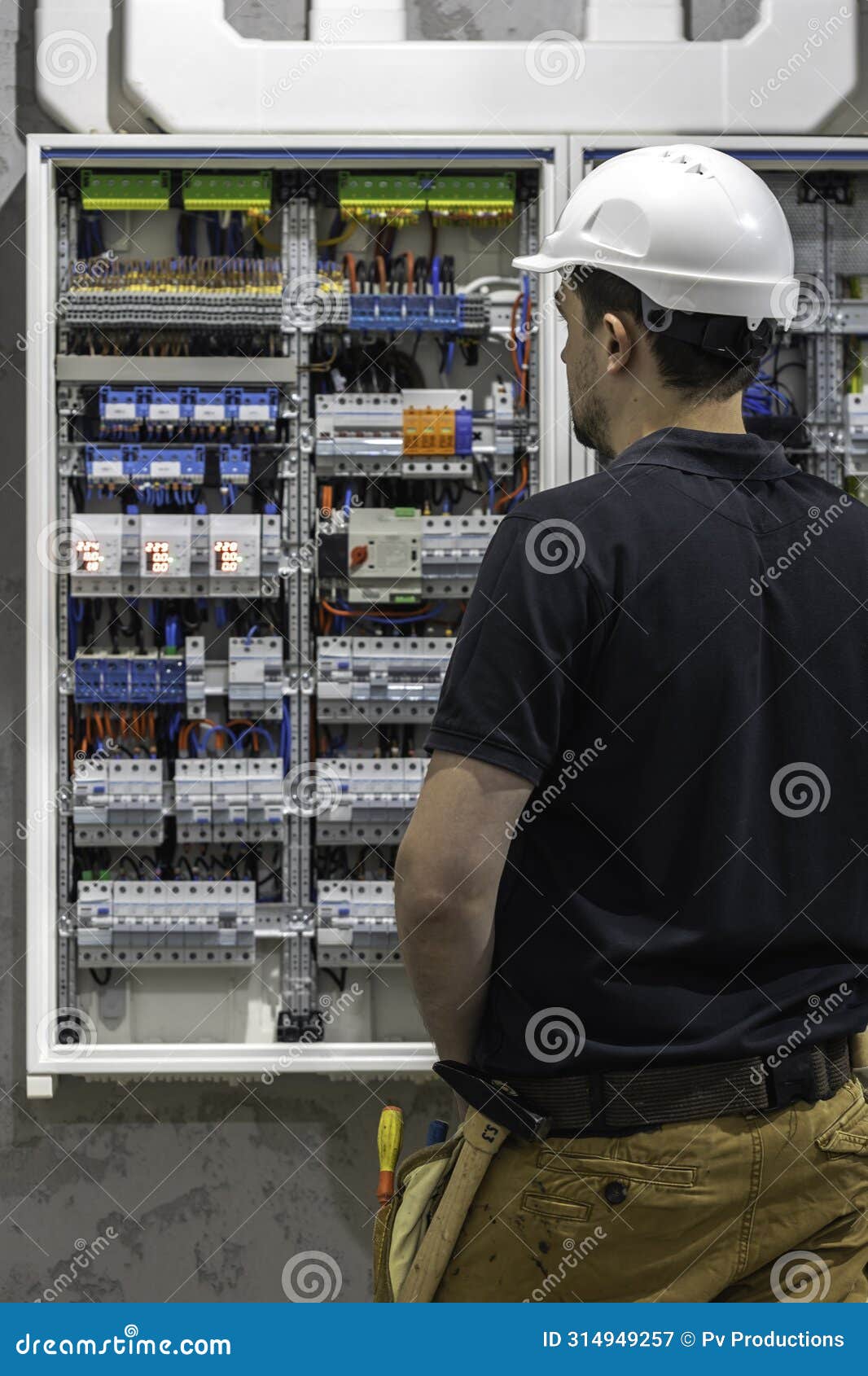 Man, an Electrical Technician Working in a Switchboard with Fuses ...