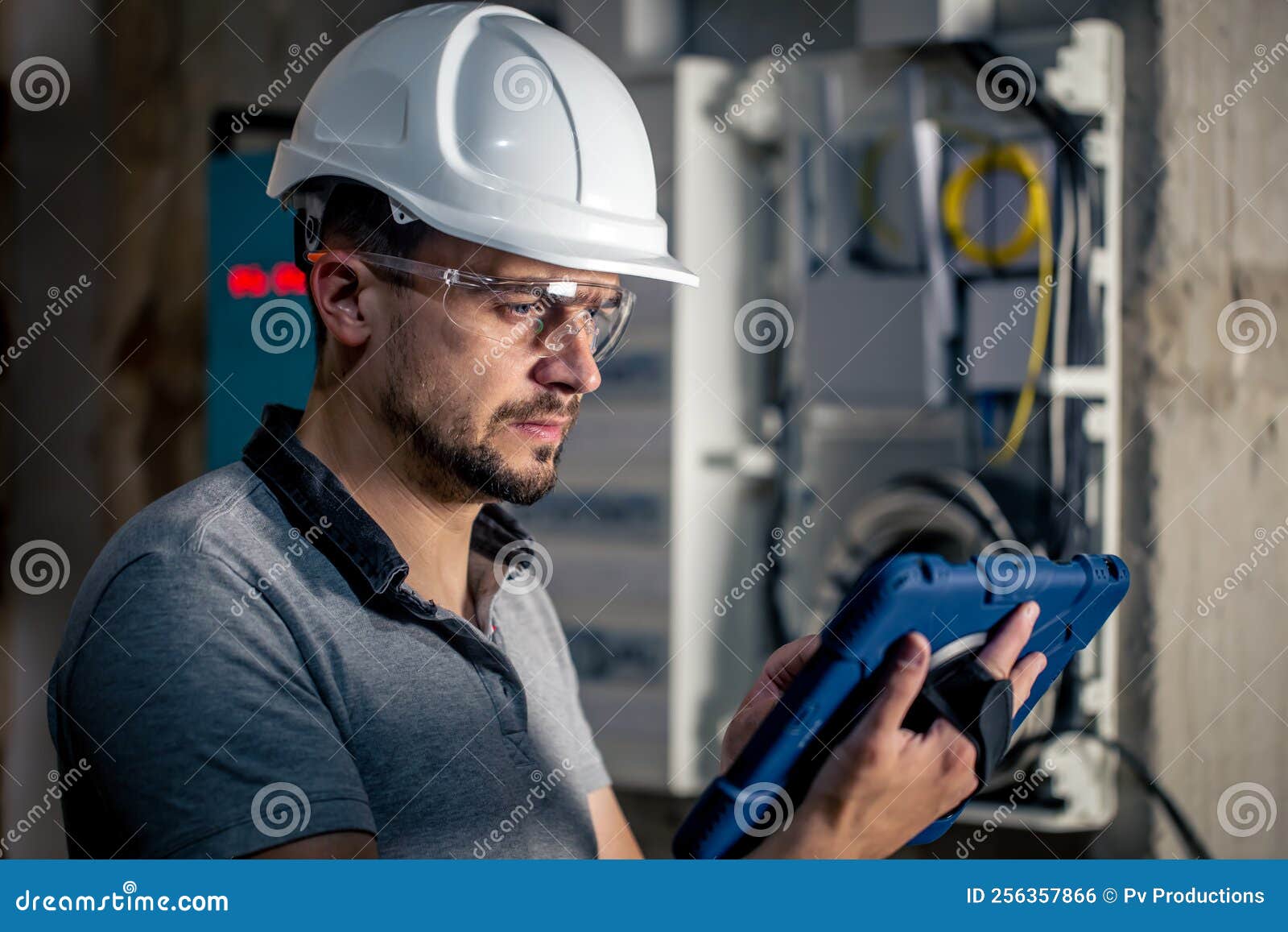 Man, an Electrical Technician Working in a Switchboard with Fuses, Uses ...