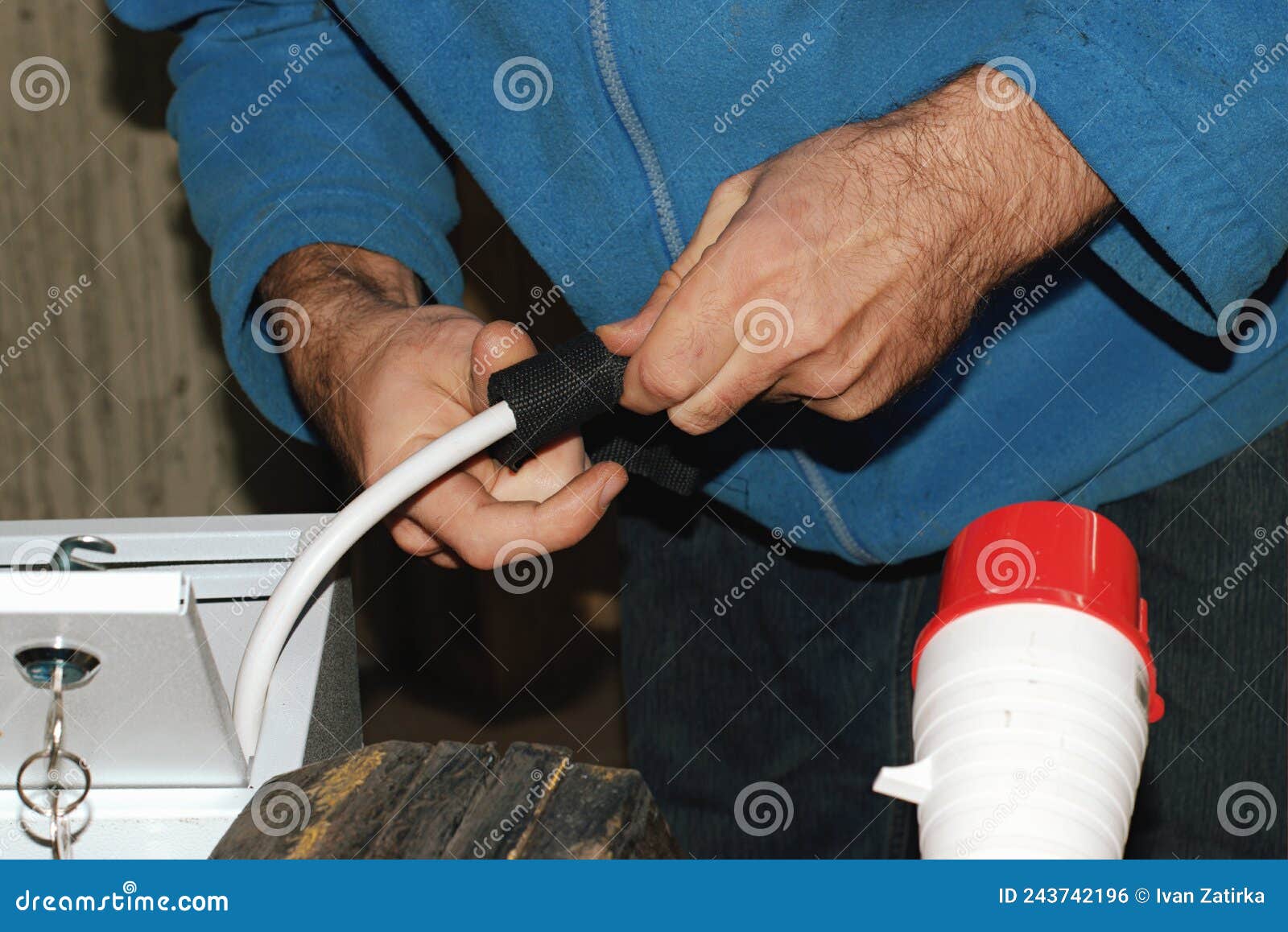 The Man is Engaged in Installation of an Electric Cable. Stock Photo ...