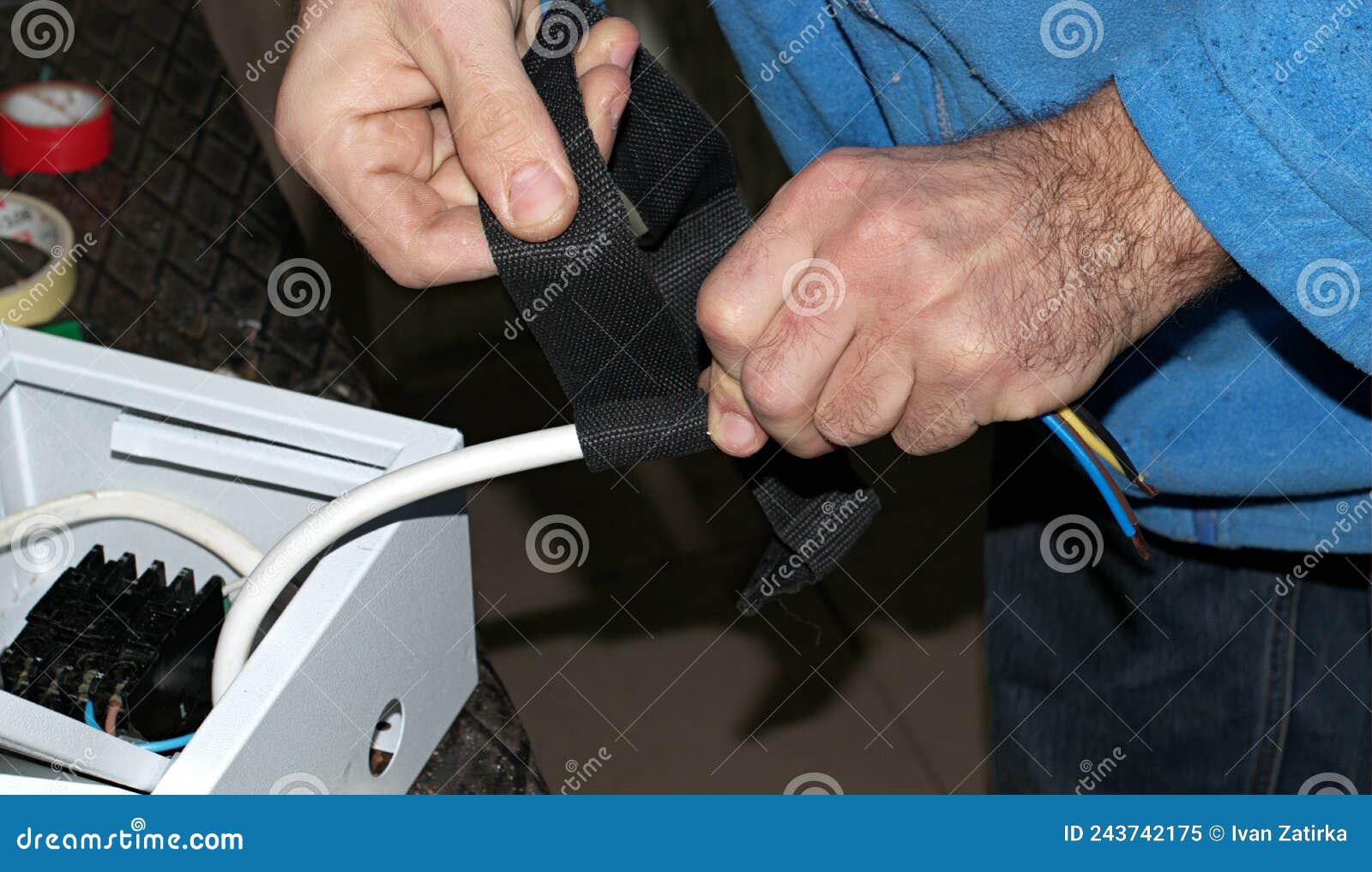 The Man is Engaged in Installation of an Electric Cable. Stock Image ...