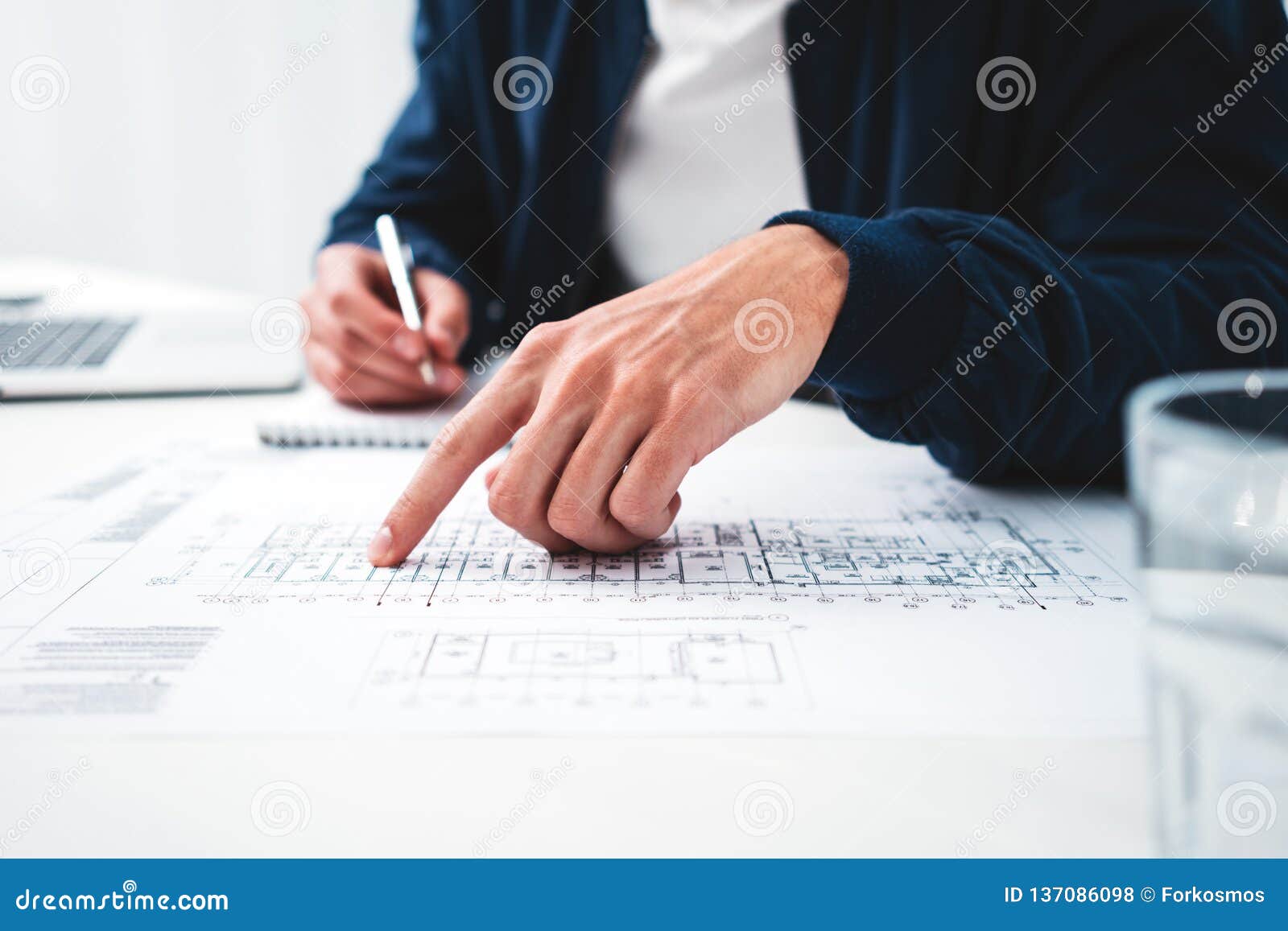 Man Engineer Looking at Drawing and Computer while Sits by the Table in ...