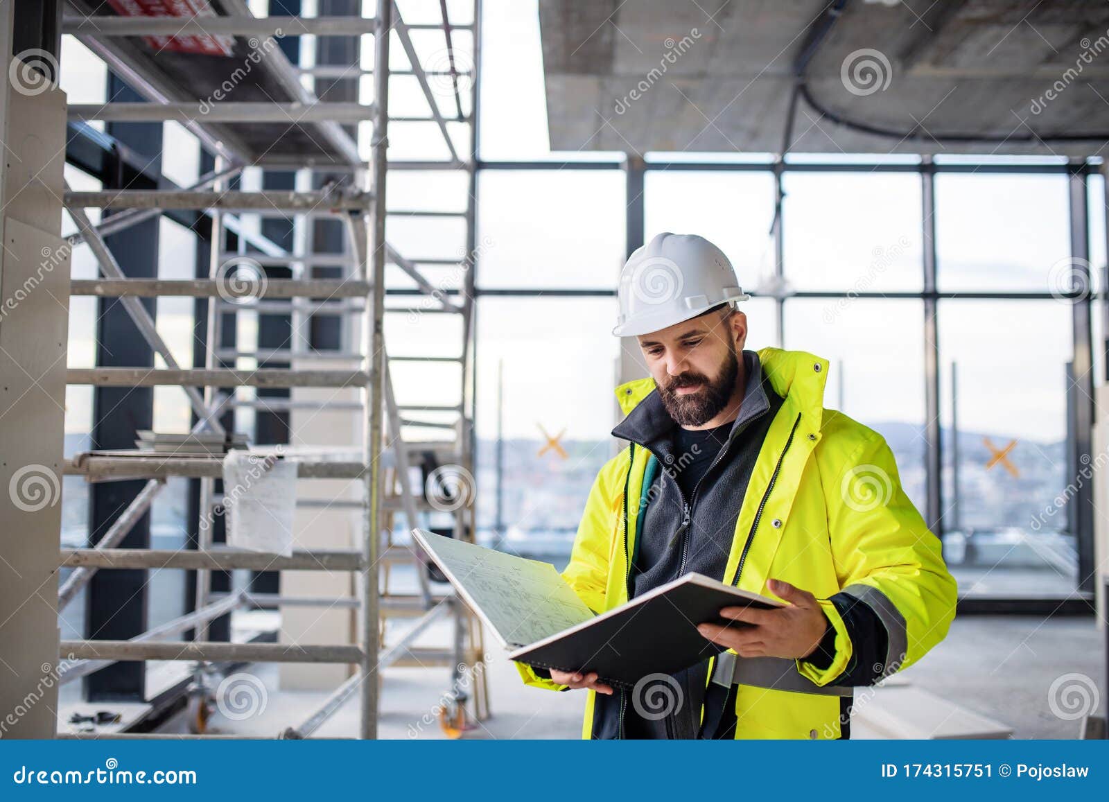 Man Engineer Standing on Construction Site, Holding Blueprints. Stock ...