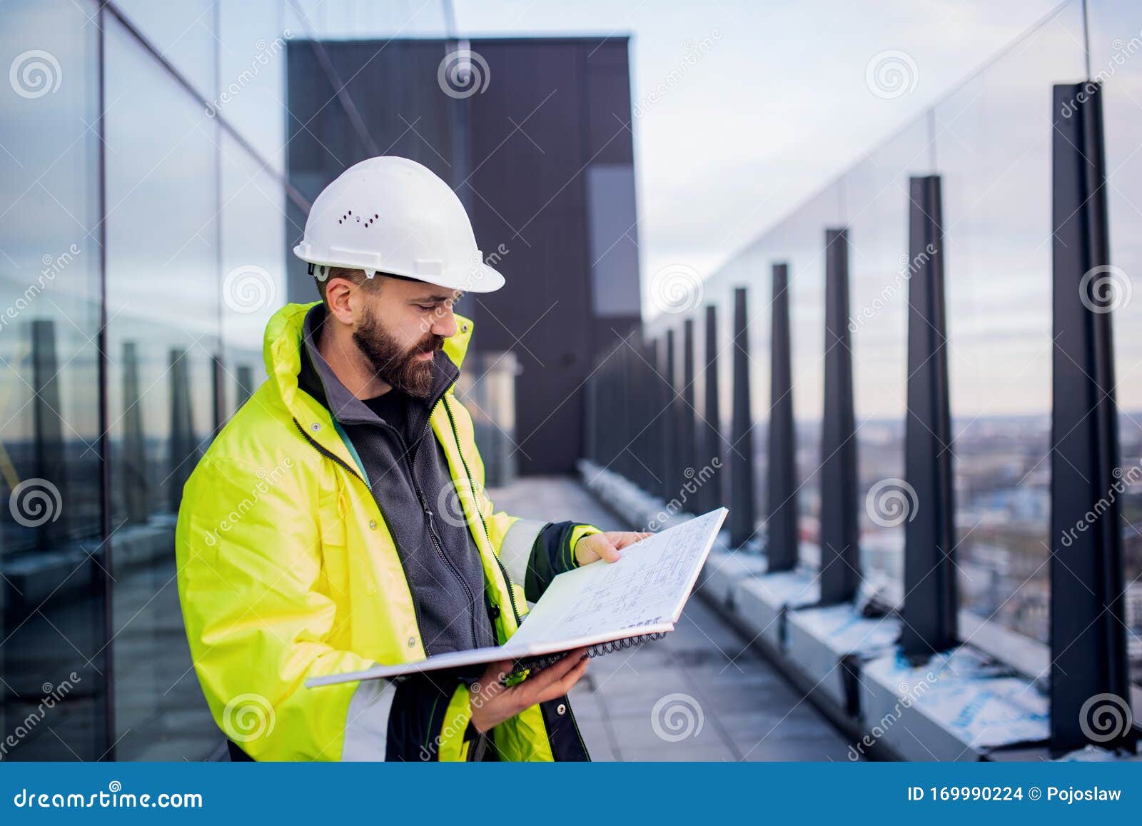 Man Engineer Standing on Construction Site, Holding Blueprints. Stock ...