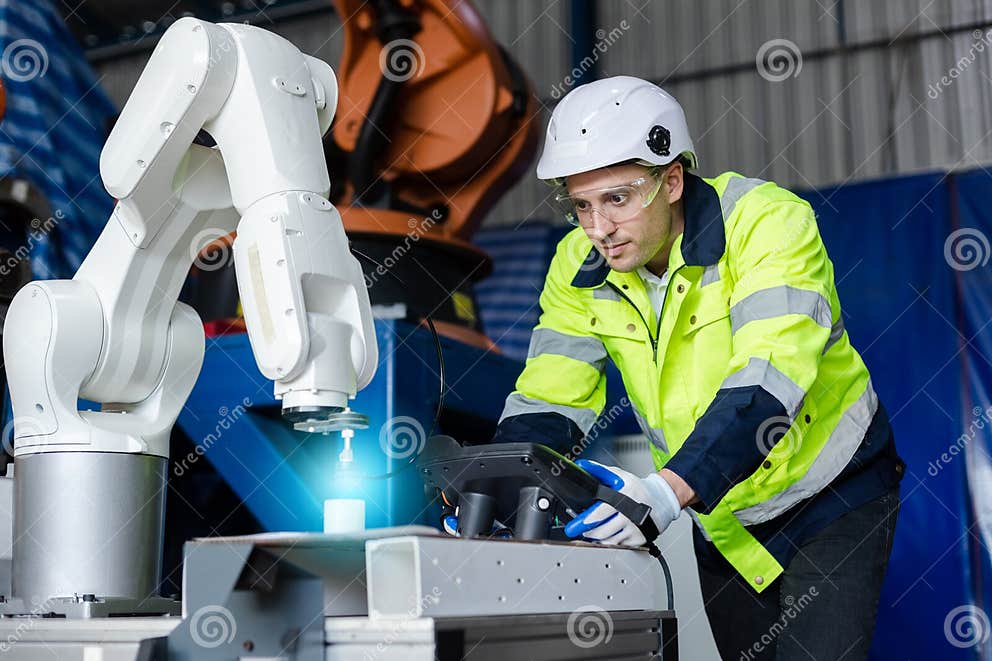 Man Engineer Using Remote Control Robot Arm Automate. Robotic Automation in Line Production at ...