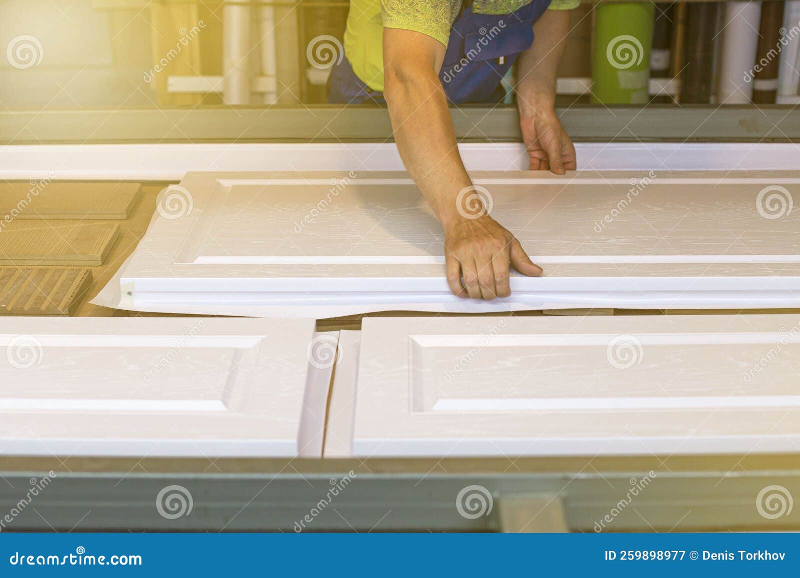 A Man Engineer Working on a Machine for Sticking a Film on an MDF Panel ...