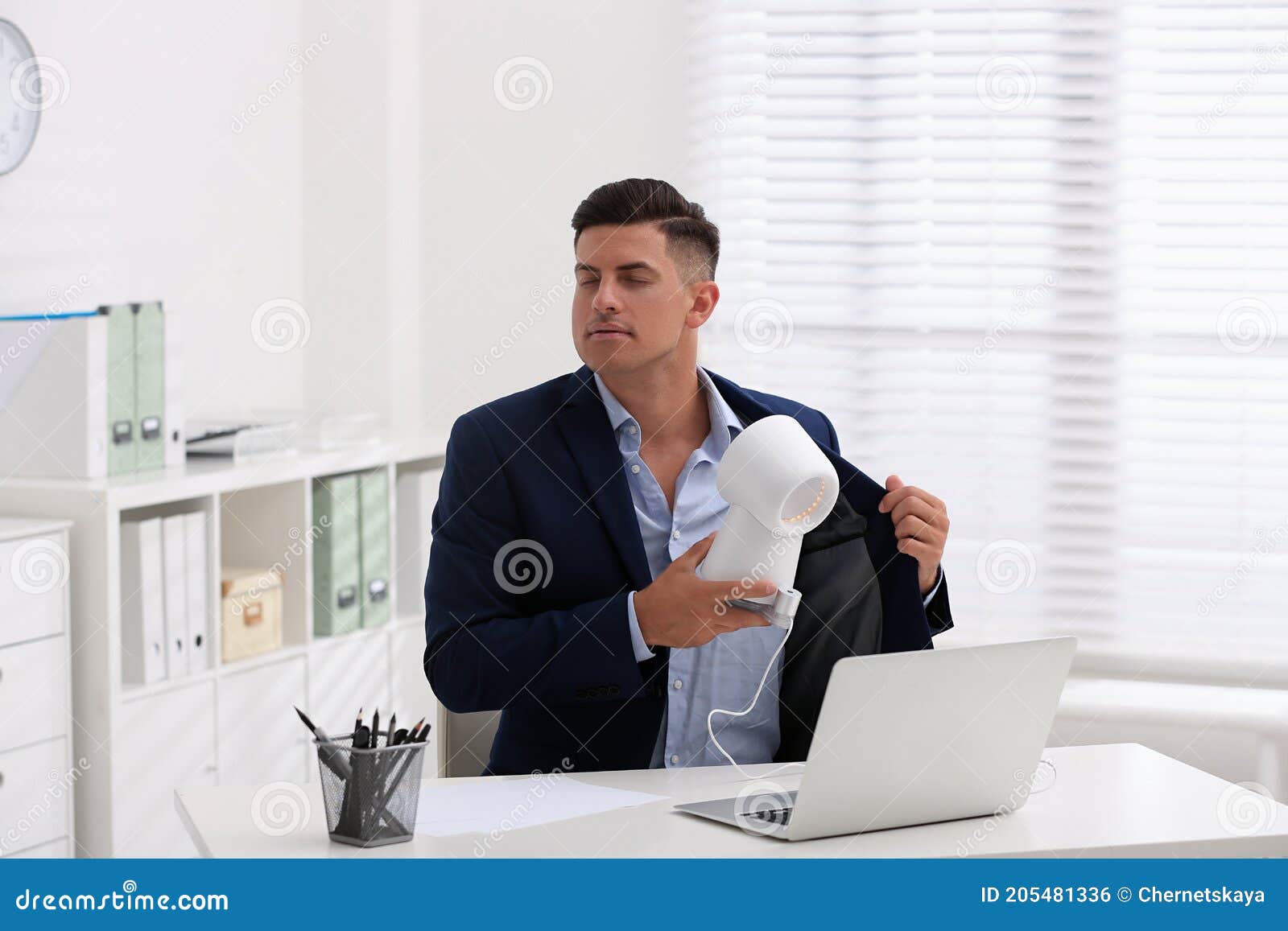 Man Enjoying Air Flow from Fan at Workplace Stock Photo - Image of ...