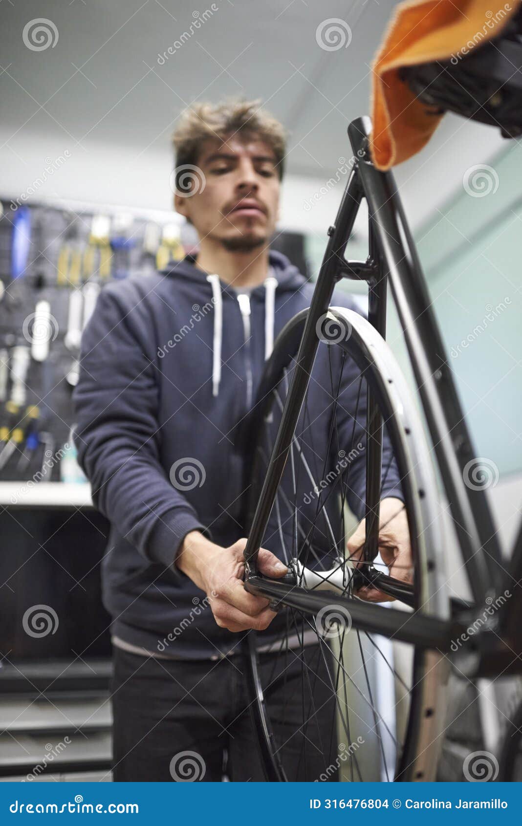 Man Evaluating the Alignment of the Rear Wheel of a Bike he is ...