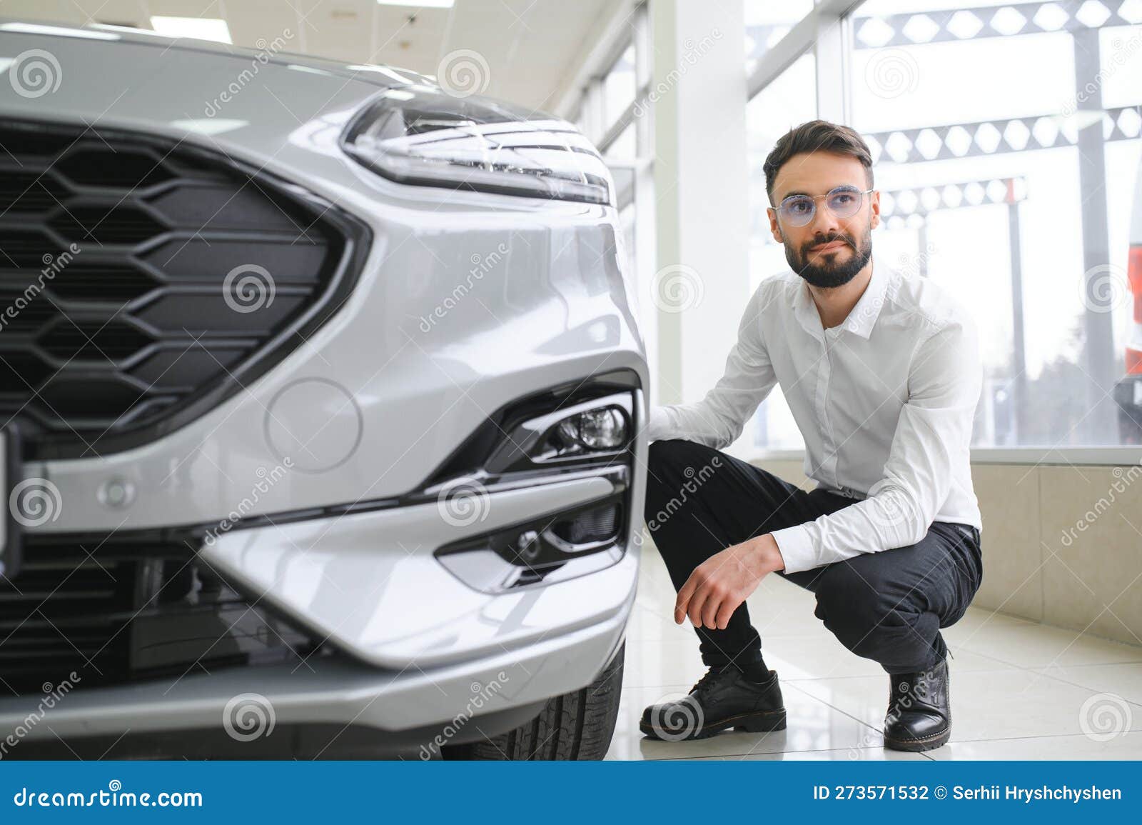A Man Examines a Car in a Car Dealership Stock Photo - Image of smiling ...