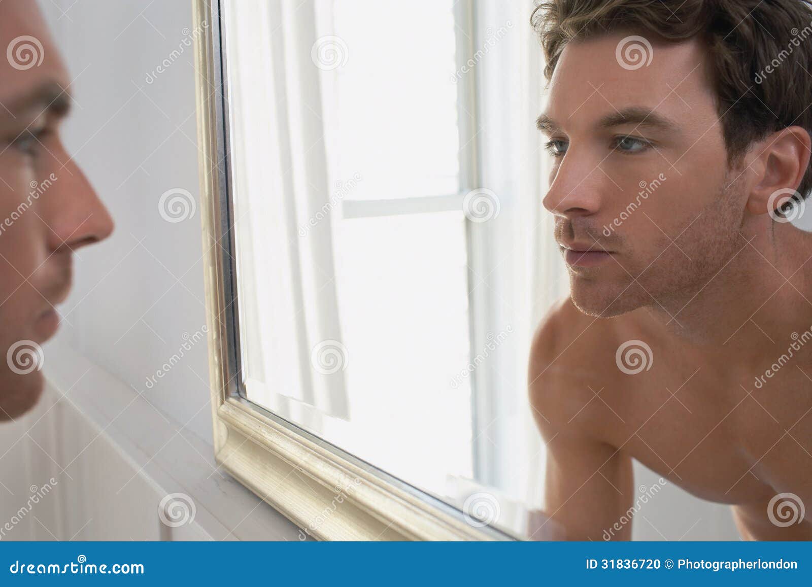 Man Examining Reflection in Mirror Stock Photo - Image of home, male ...