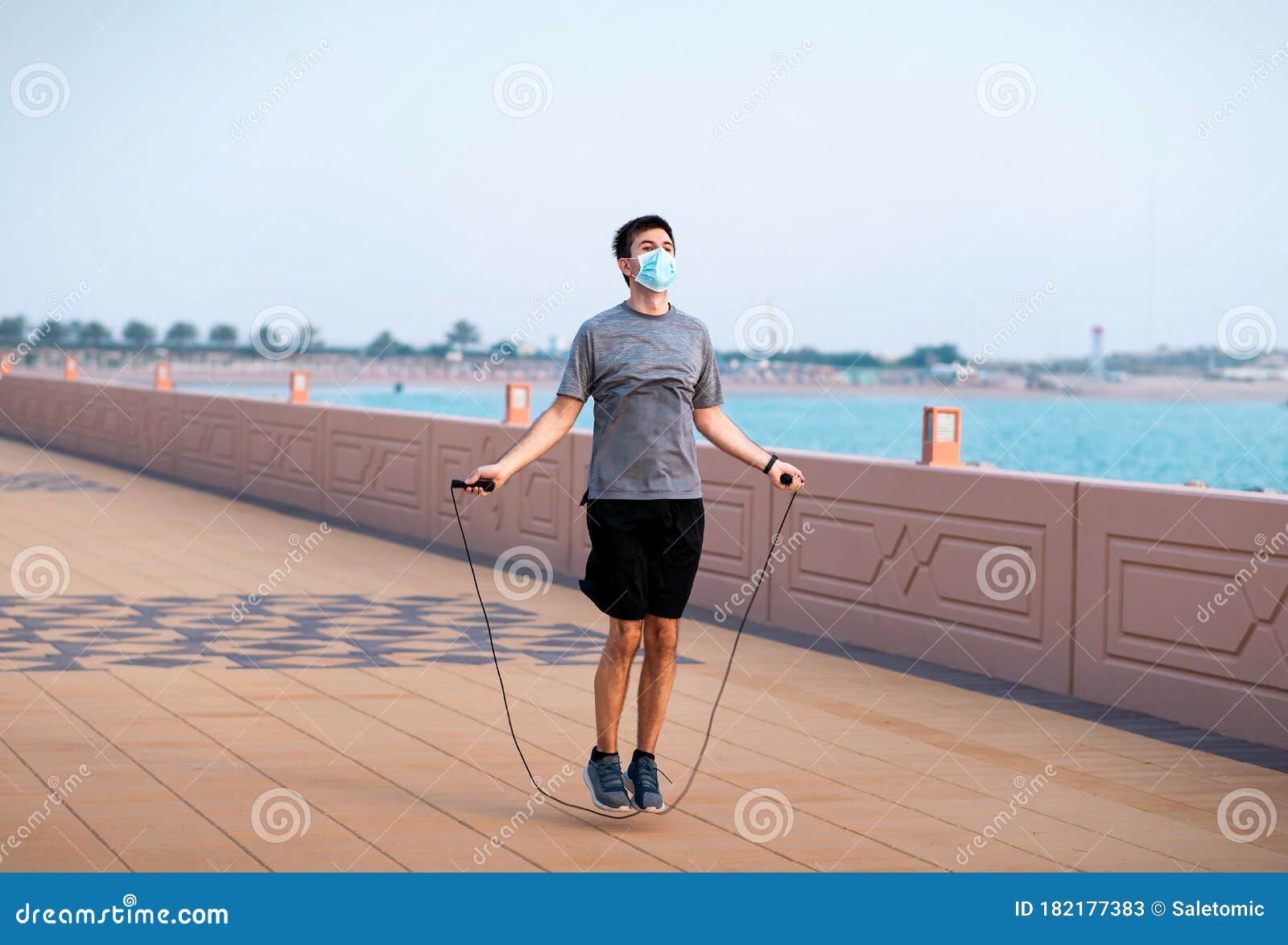 Man Exercising with a Jumping Rope and Wearing Protective Surgical Mask ...