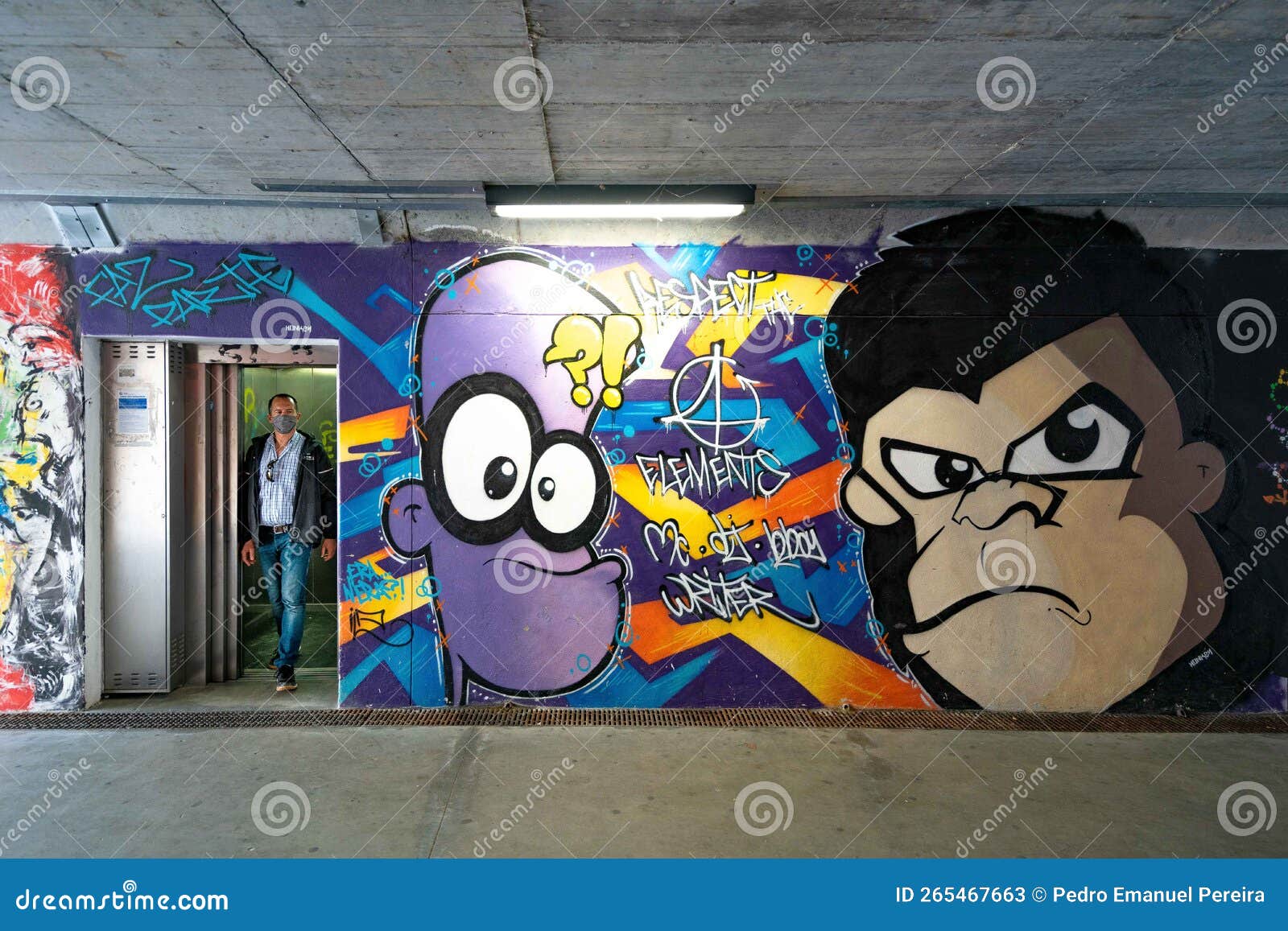 Man Exiting the Elevator Door in an Area with an Urban Art Wall ...