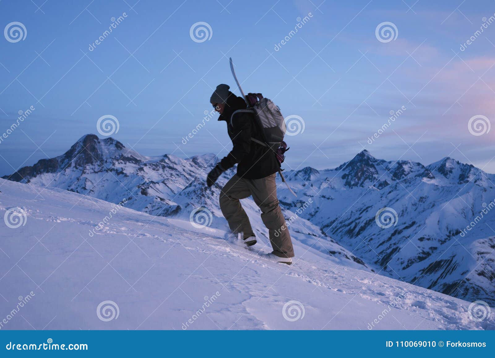 Man Explorer with a Snowboard Behind His Back Climb on High Mountain ...