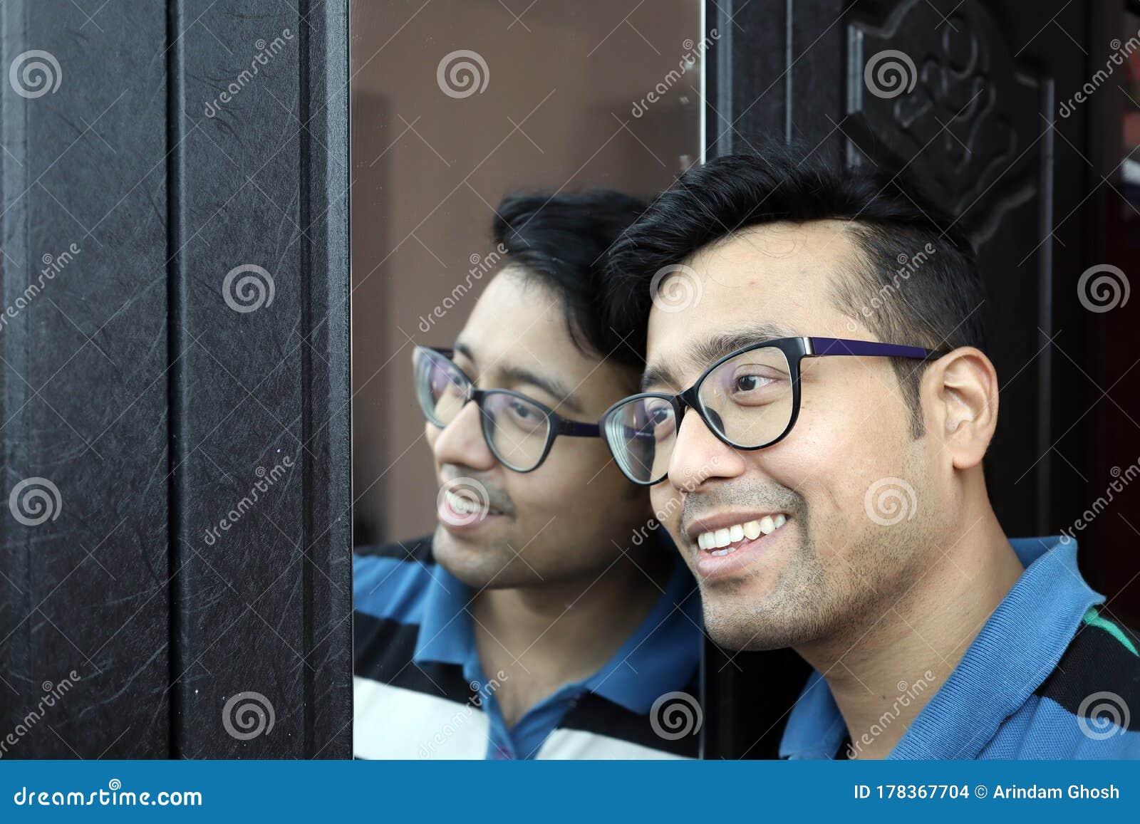 A Man in Eye Glasses and His Reflection in Mirror Smiling in Happy Mood ...