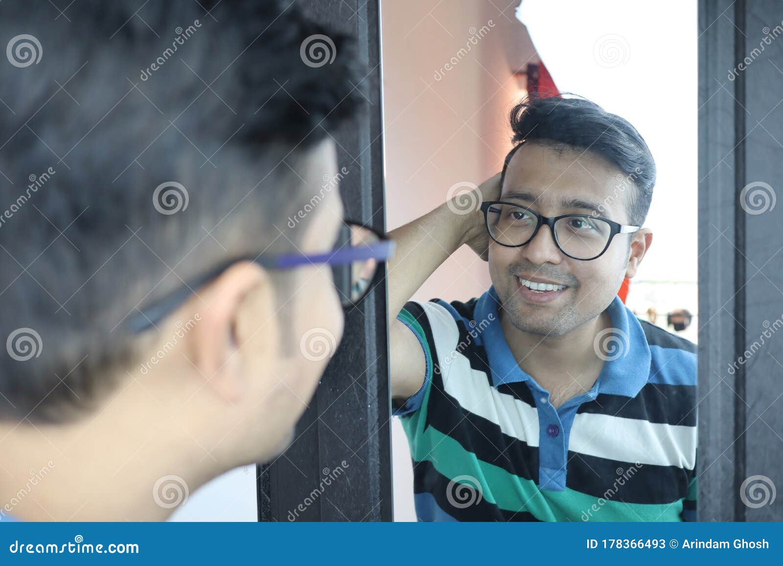 A Man with Eyeglass Looking at His Reflection in Mirror and Smiling at ...