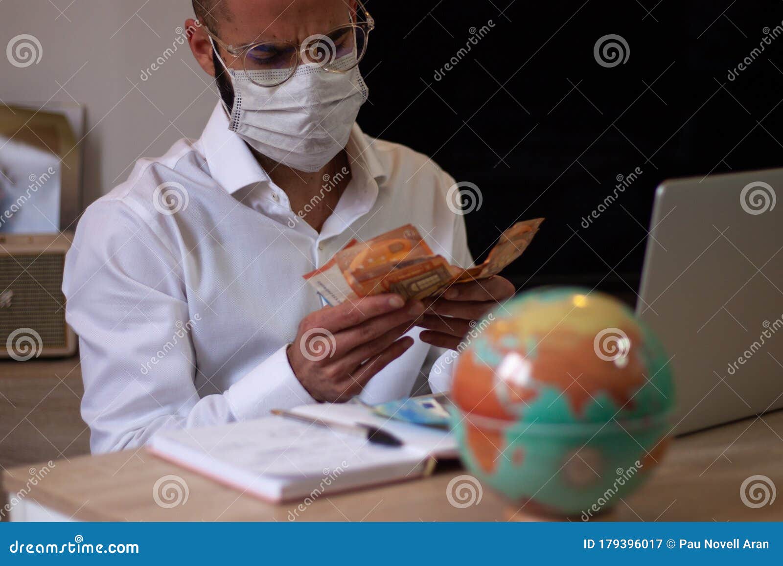 Man with Face Mask Holding a Stack of Cash, Financial Adviser Working ...