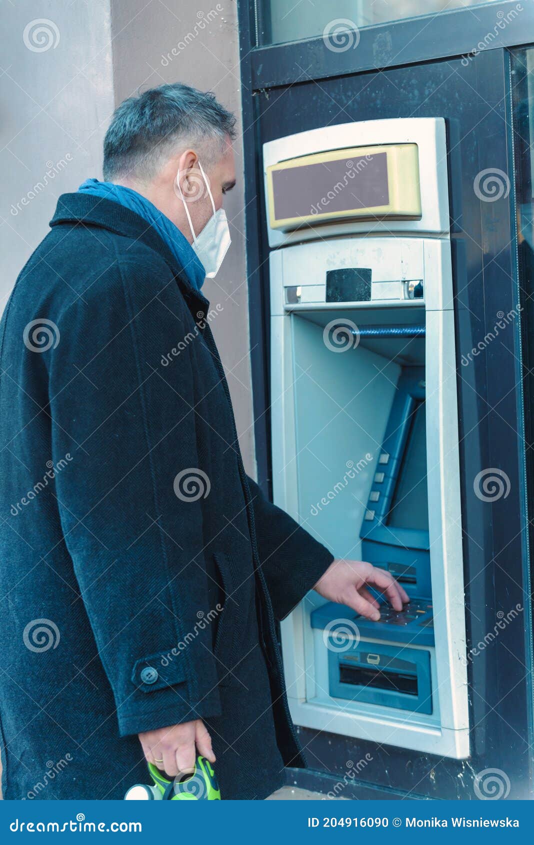 Man in face mask using ATM stock photo. Image of payment - 204916090