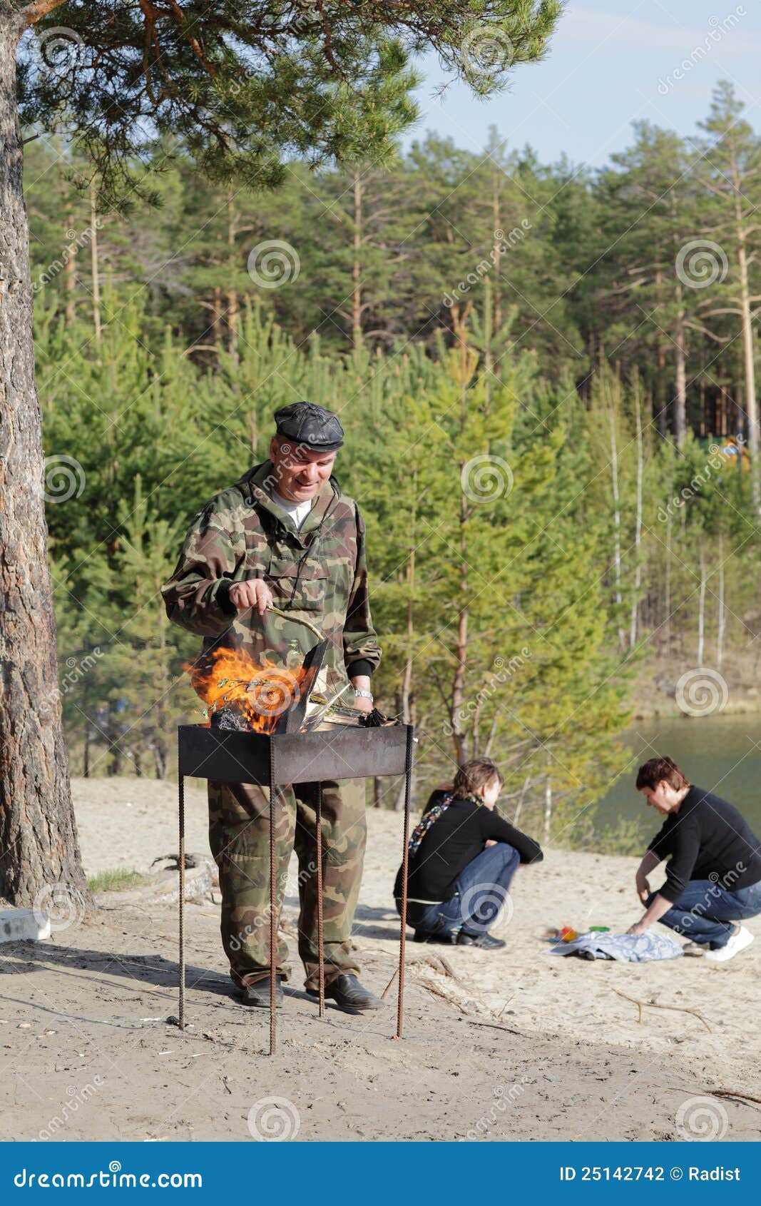 Man fanning fire in grill stock photo. Image of people - 25142742