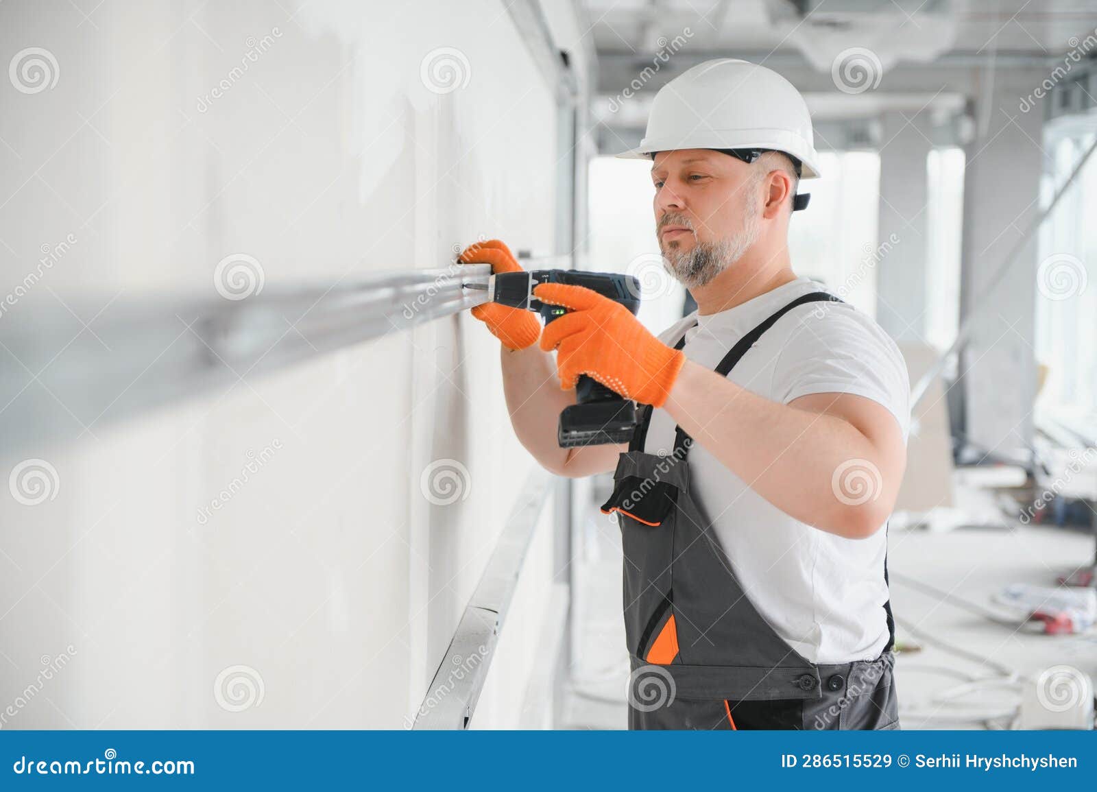 Man Fasten Metal Profile Frame To the Wall for Draywall Bulkhead. Stock ...