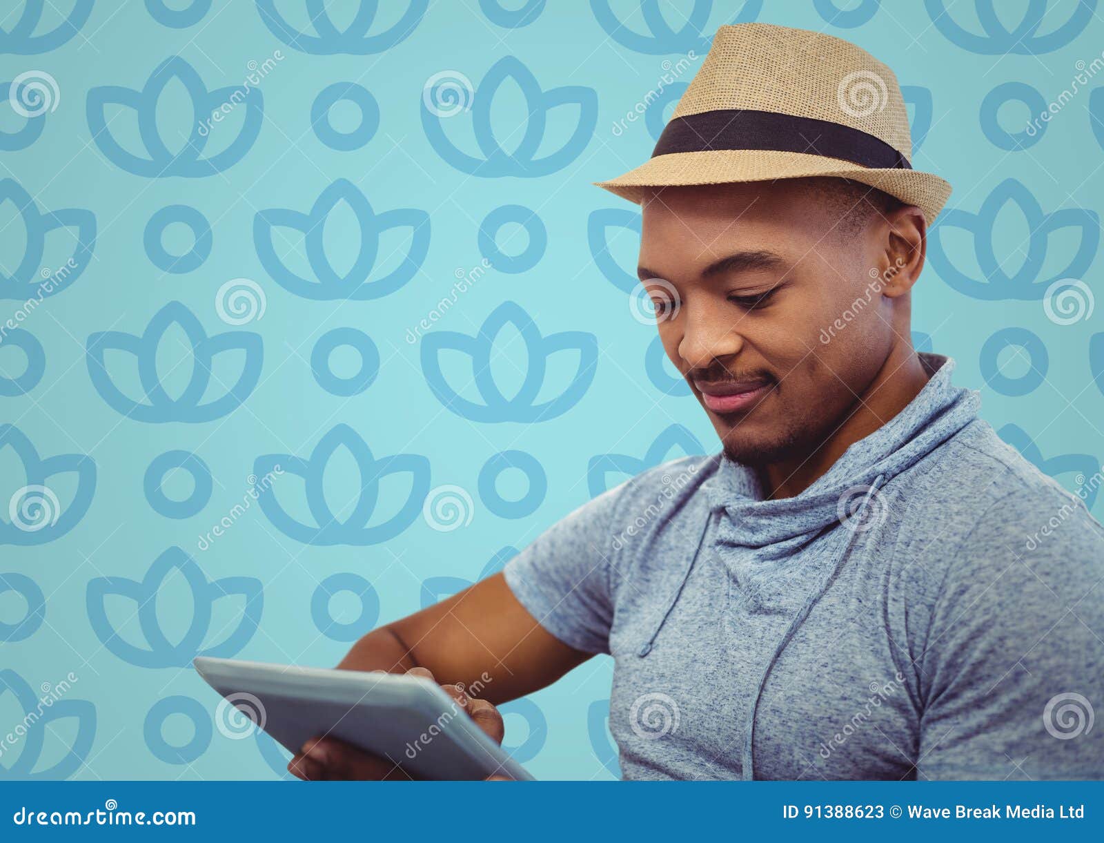 Man in Fedora with Tablet Against Blue Floral Pattern Stock Image ...