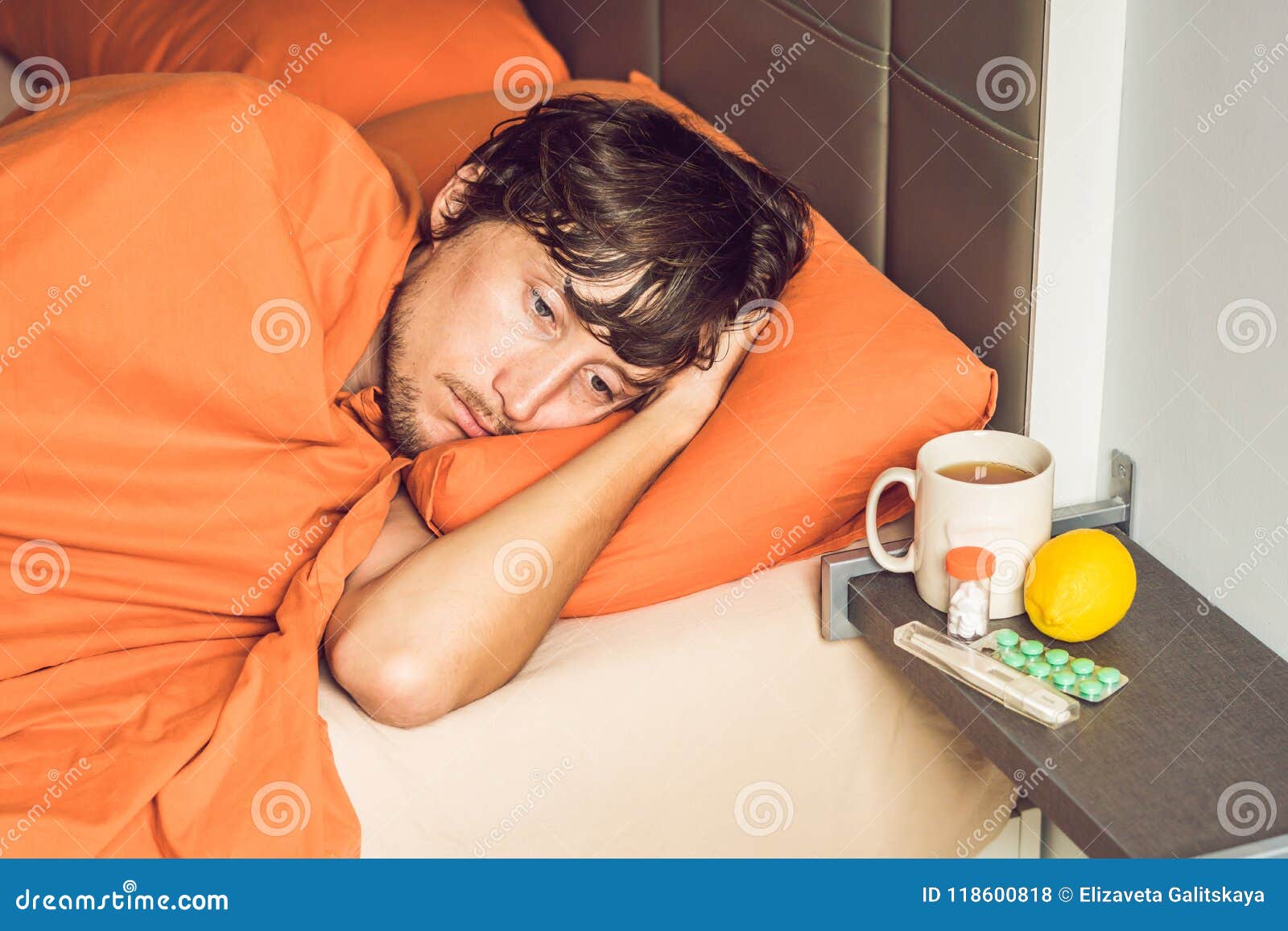 Man Feeling Cold, Lying in the Bed and Drinks Tea and Measures T Stock ...