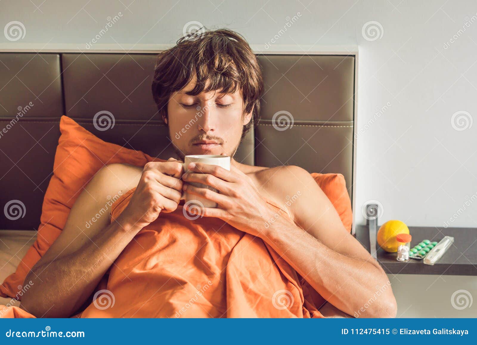 Man Feeling Cold, Lying in the Bed and Drinks Tea and Measures ...