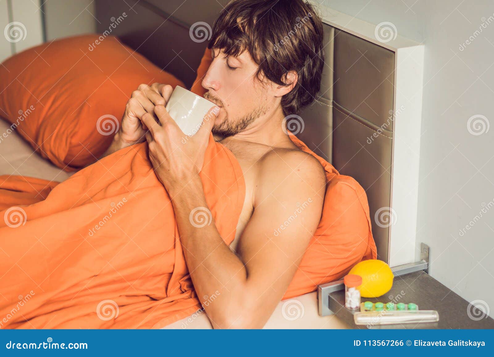Man Feeling Cold, Lying in the Bed and Drinks Tea and Measures ...