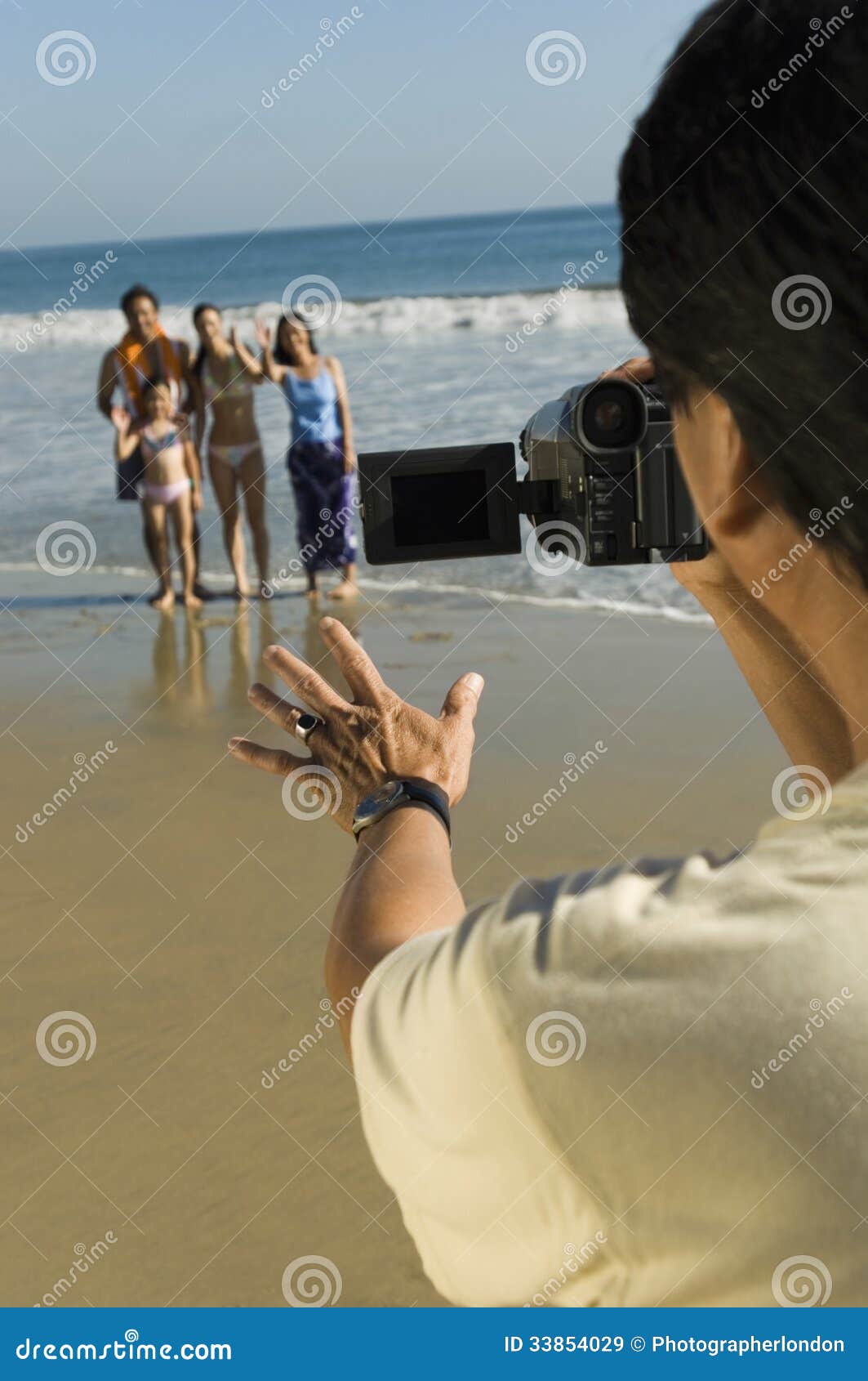 Man Filming Family on Beach Stock Image - Image of gesturing, girl ...