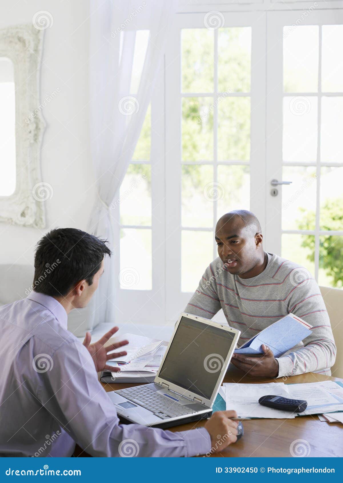 Man with Financial Advisor at Table Stock Photo - Image of document ...