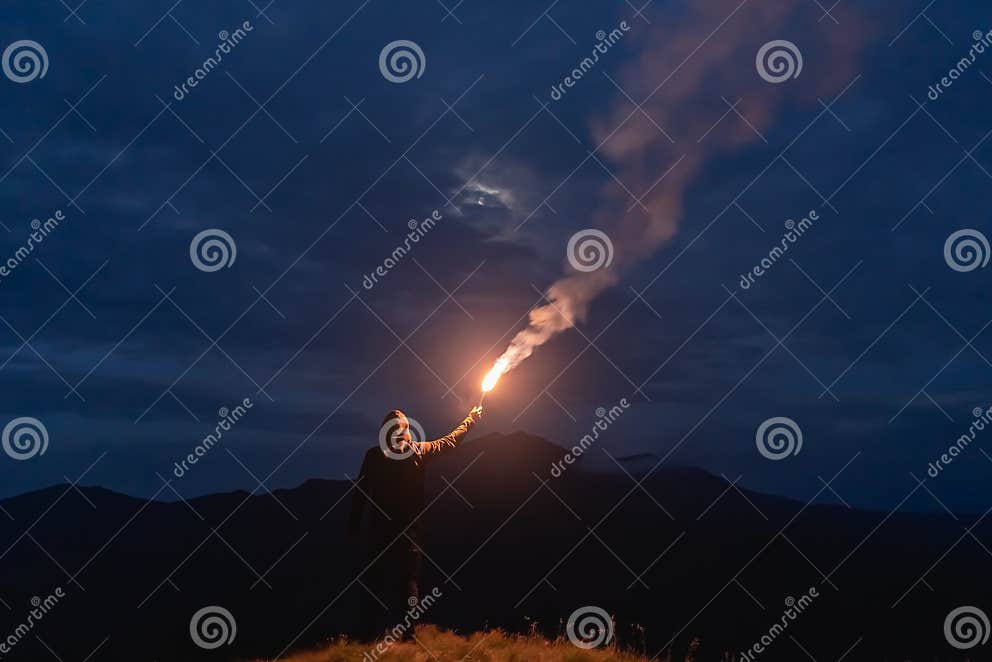 The Man with a Firework Stick Standing on a Mountain. Stock Photo ...