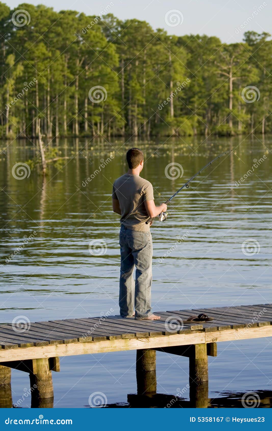 Man fishing off a dock stock image. Image of lake, male - 5358167