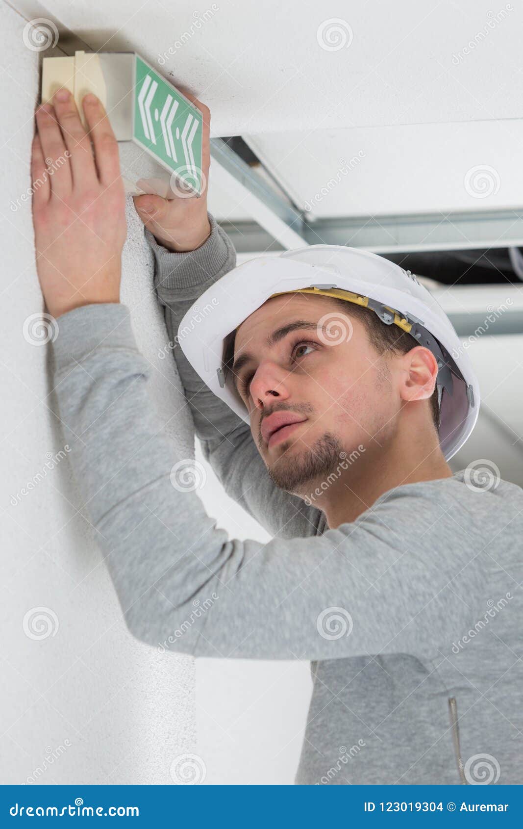 Man Fitting Directional Exit Sign To Wall Stock Photo - Image of exit ...