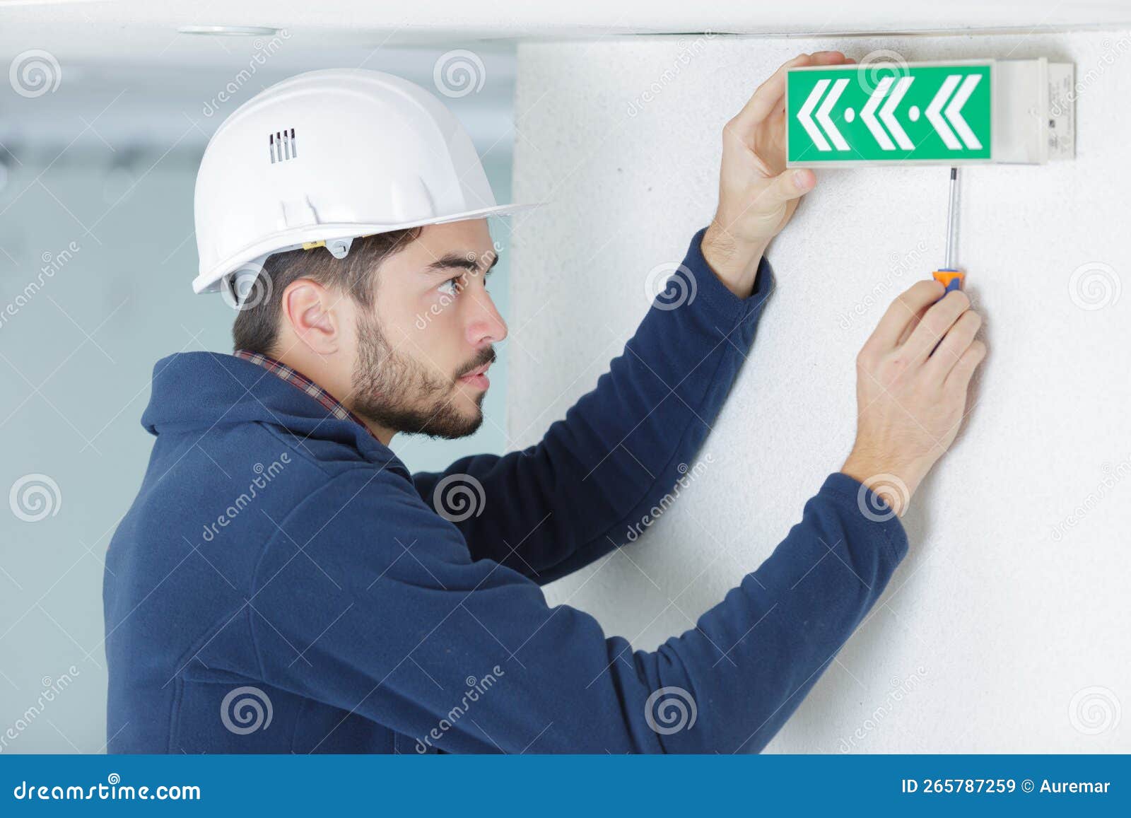 Man Fitting Illuminated Exit Sign To Wall Stock Image - Image of ...