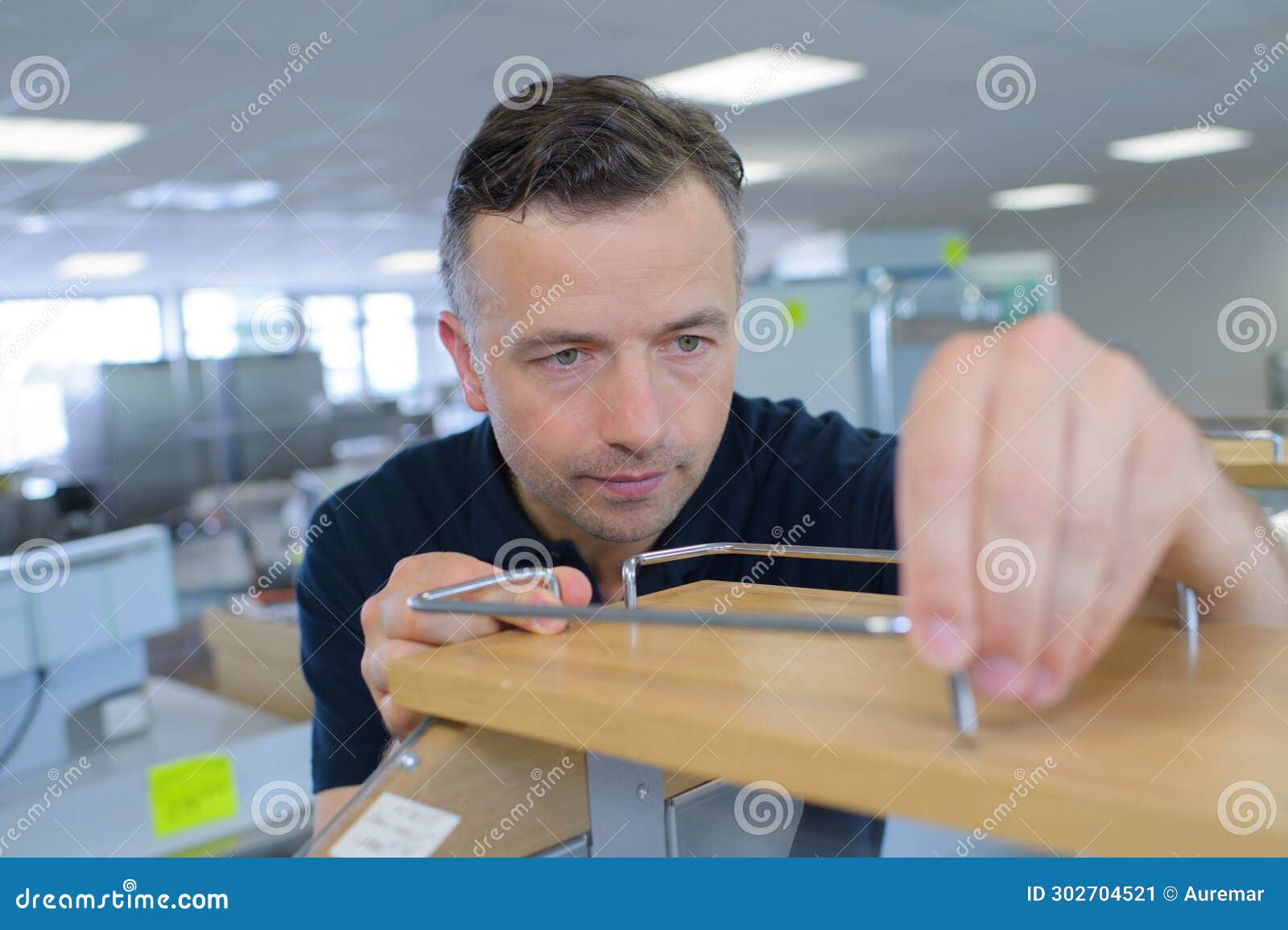 Man Fitting Metal Edging Bar To Shelving Unit Stock Image - Image of ...