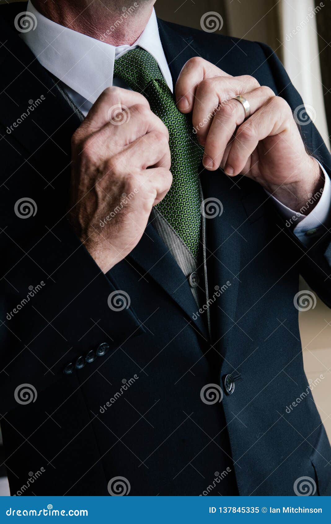 Man fixes tie in a suit stock image. Image of business - 137845335